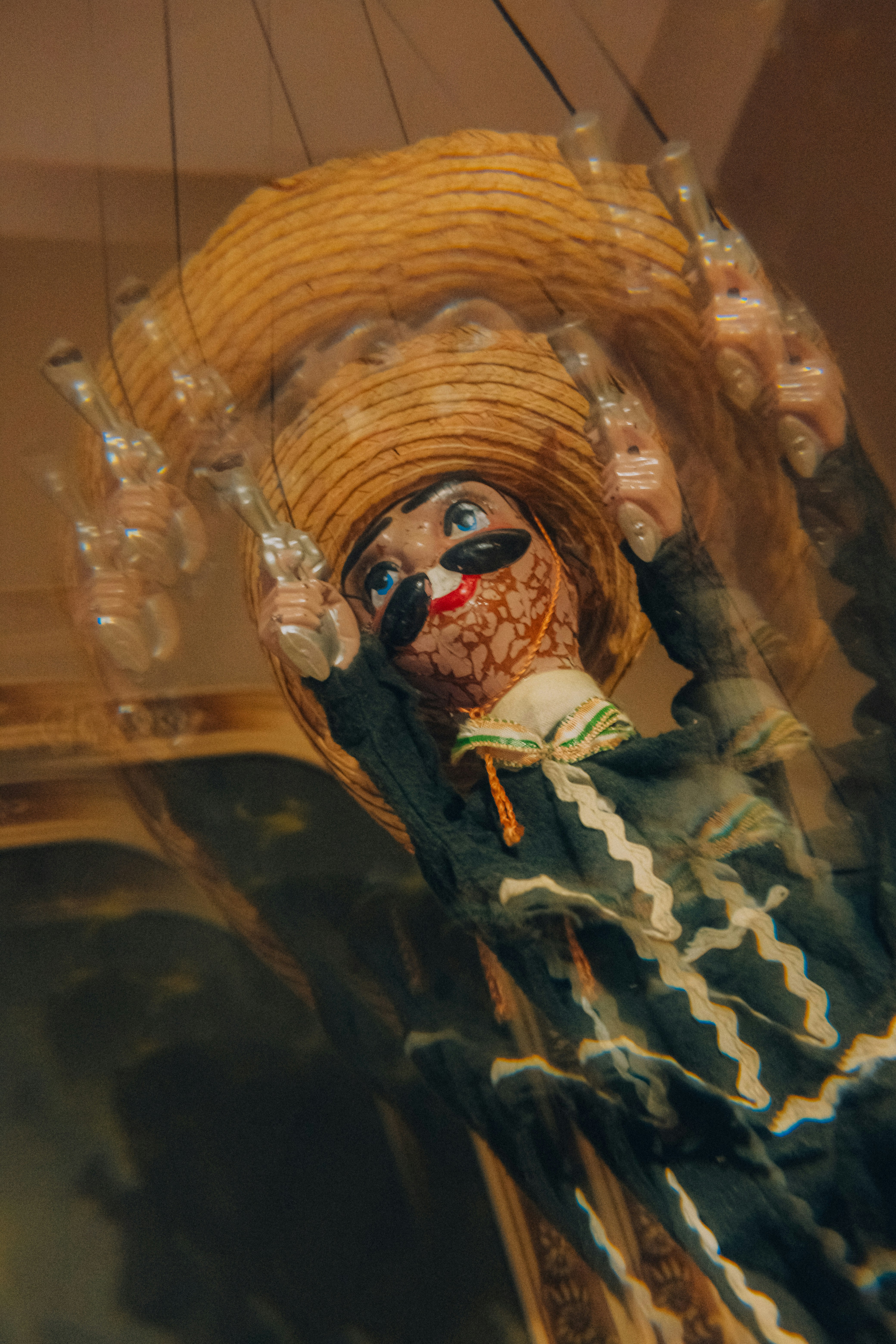 Whimsical Lantern-Wearing Figure Behind Glass