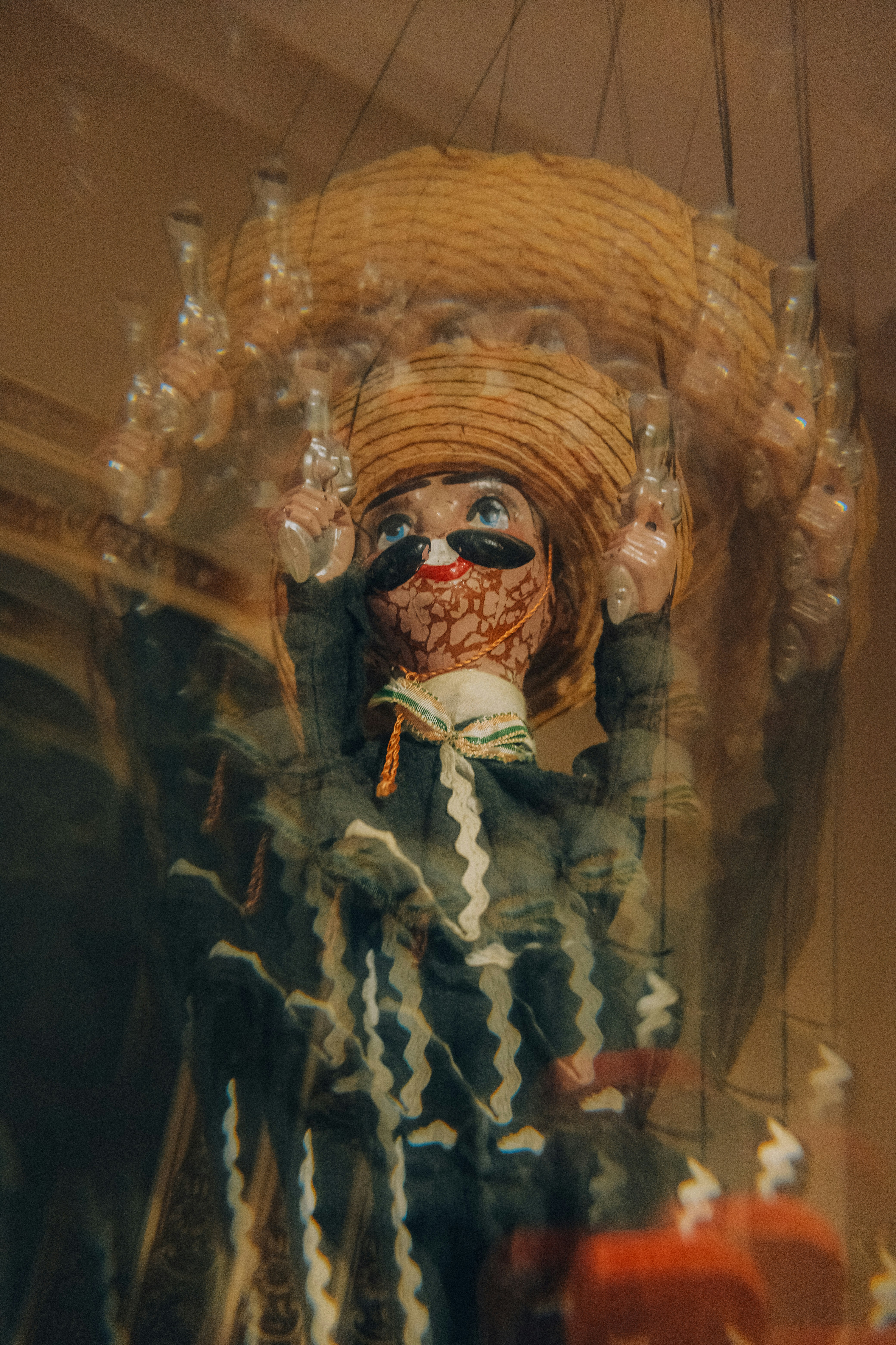 Masked Maestro Under Glass: A Dressed Figurine Surrounded by Bottles