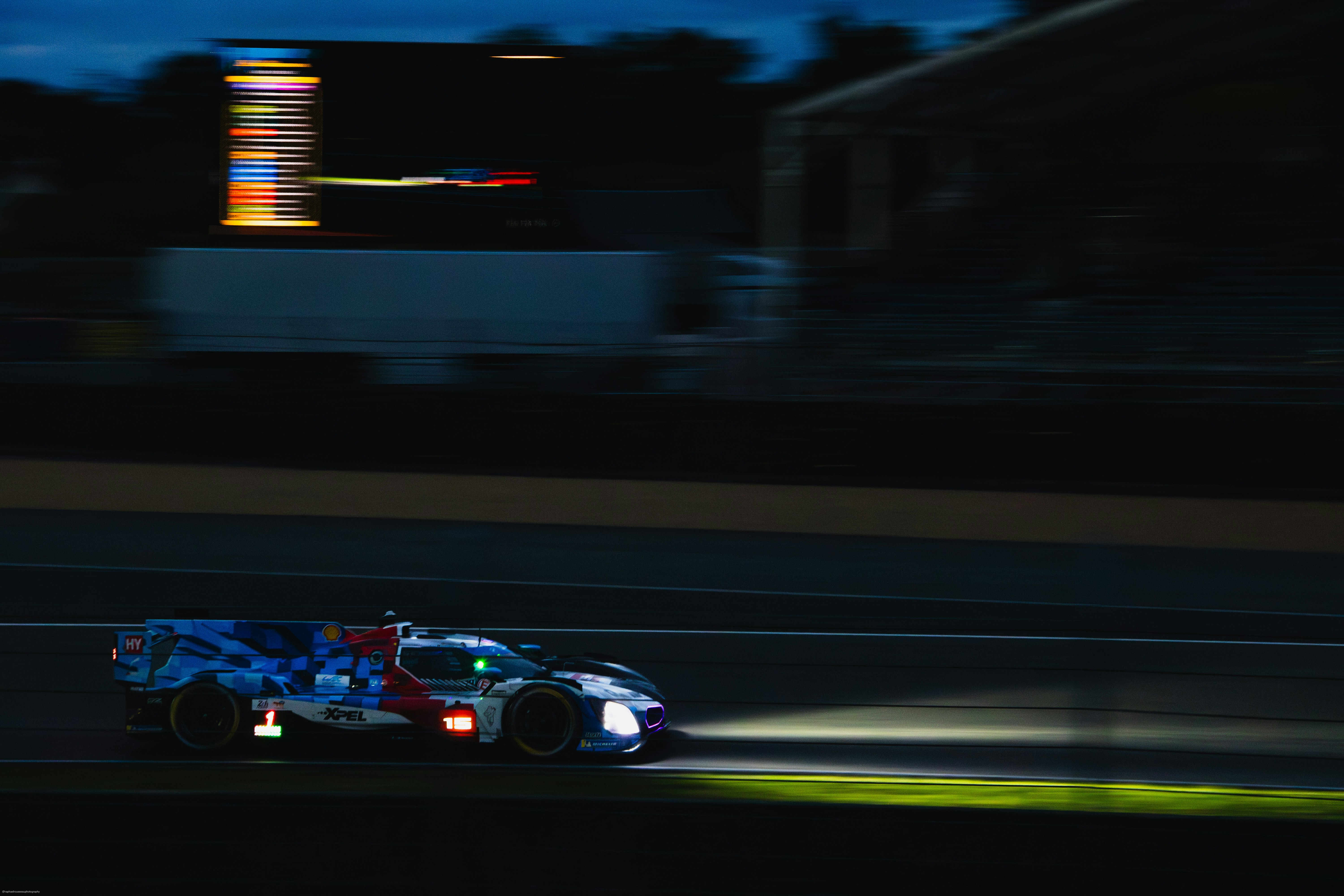 Low Night Pass: A Sprint Car in Blue Camouflage Blurs Across the Track