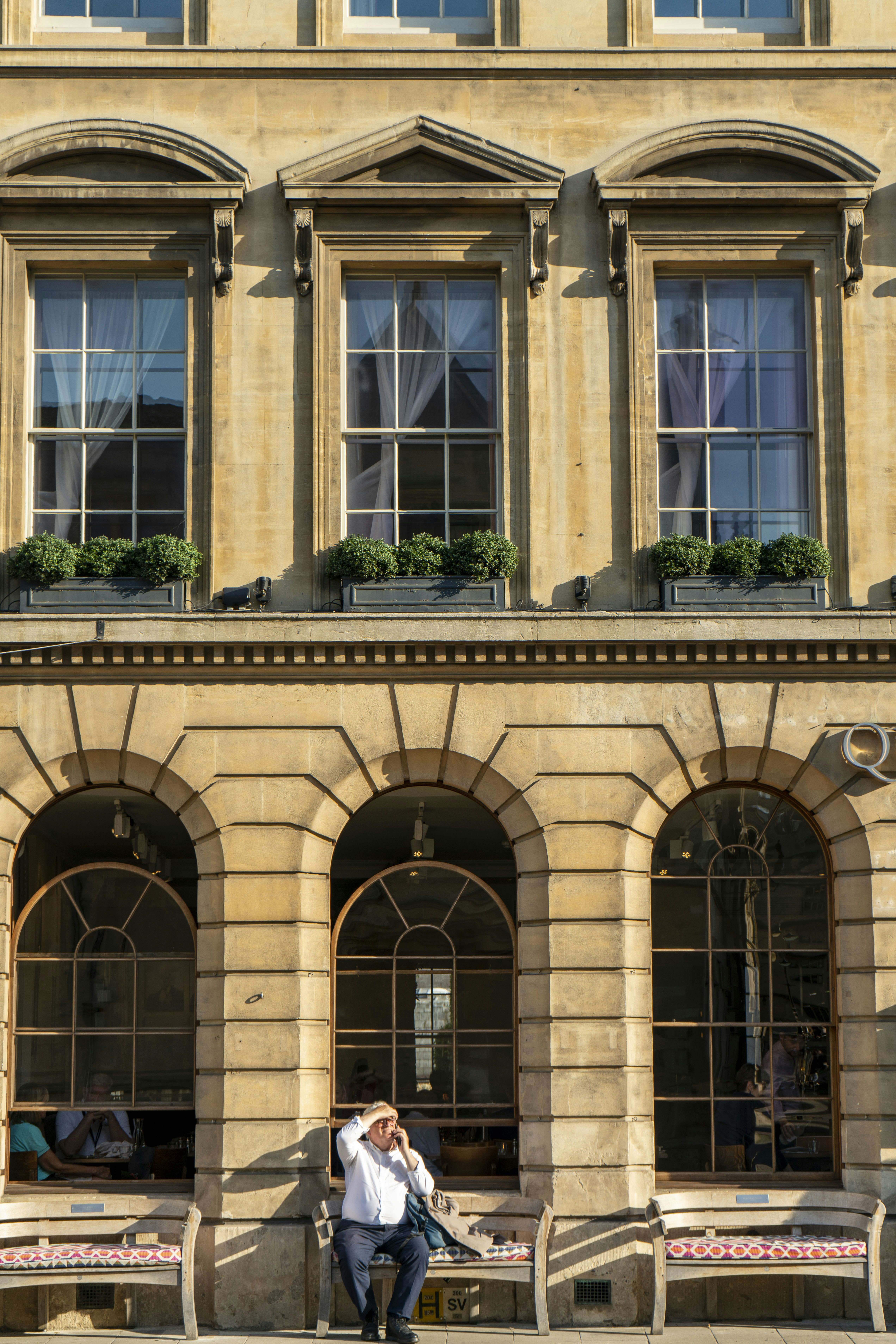 A Sunlit Facade and a Pause for the Portrait