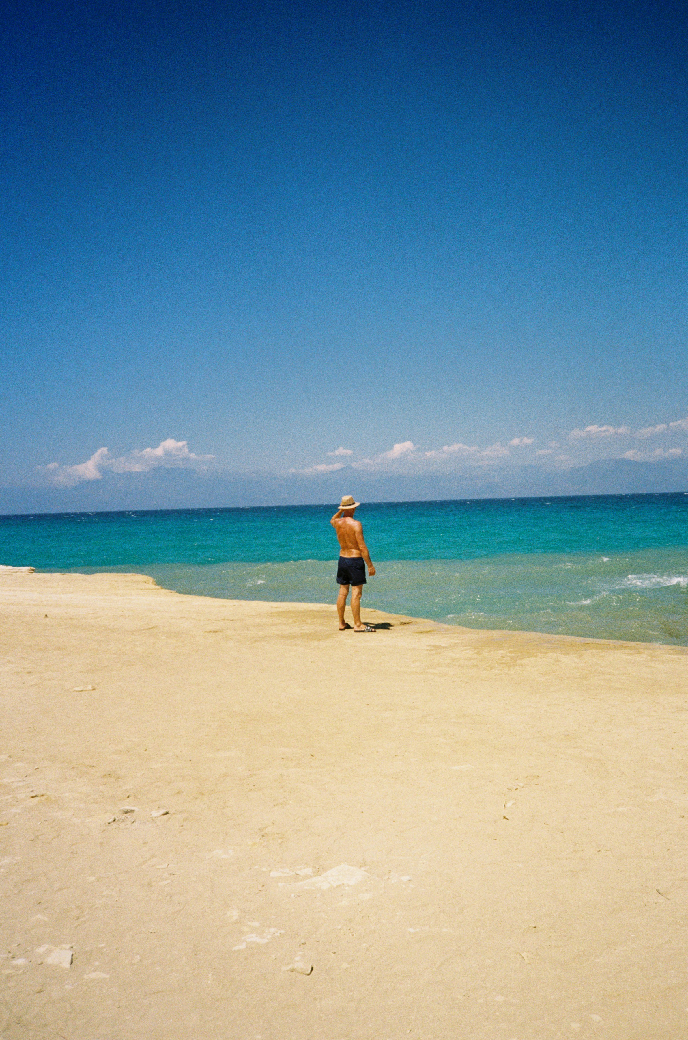 Solitary Wanderer at the Edge of Turquoise Waves