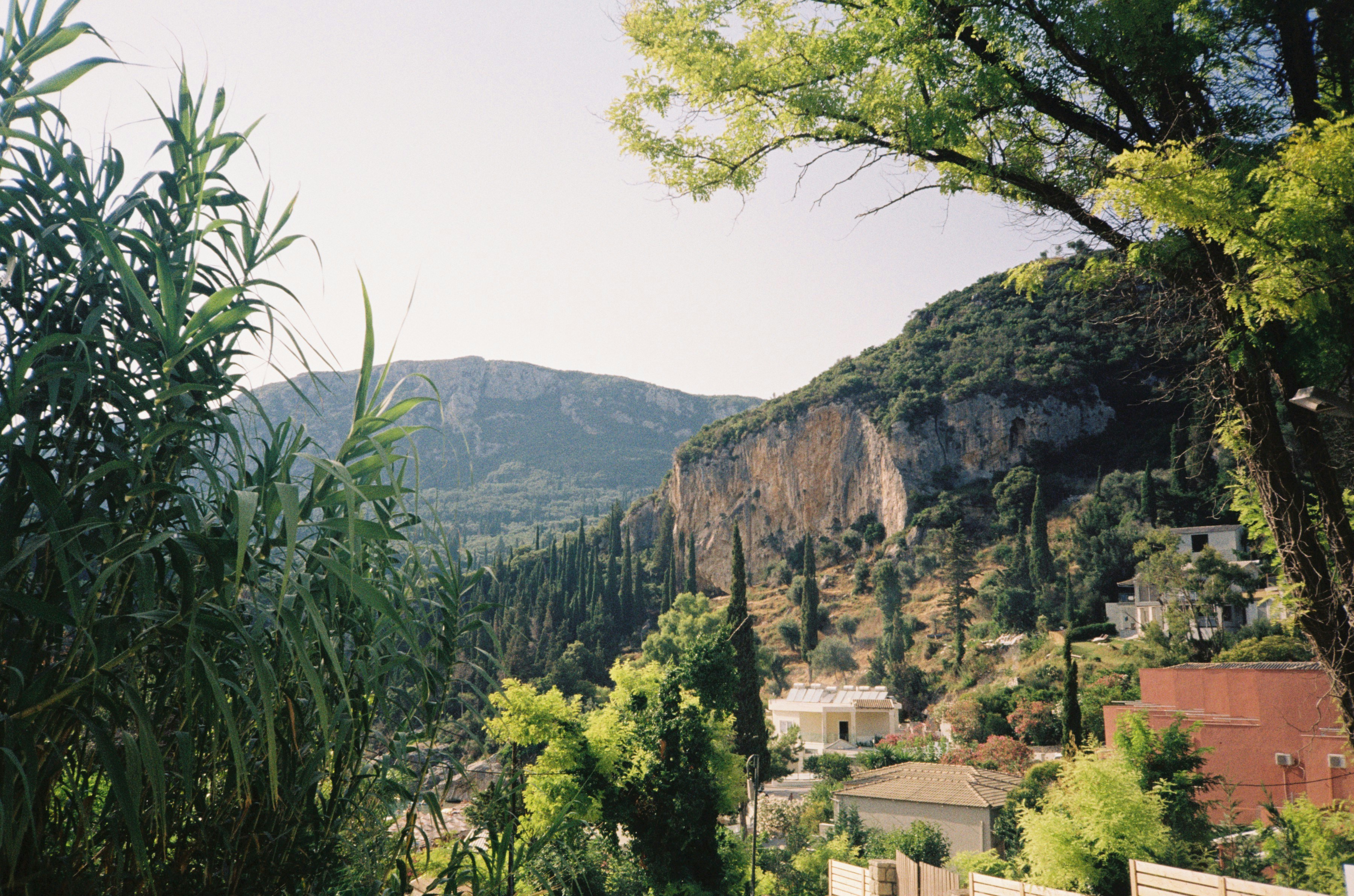 Sunlit hillside village tucked beneath a rugged cliff
