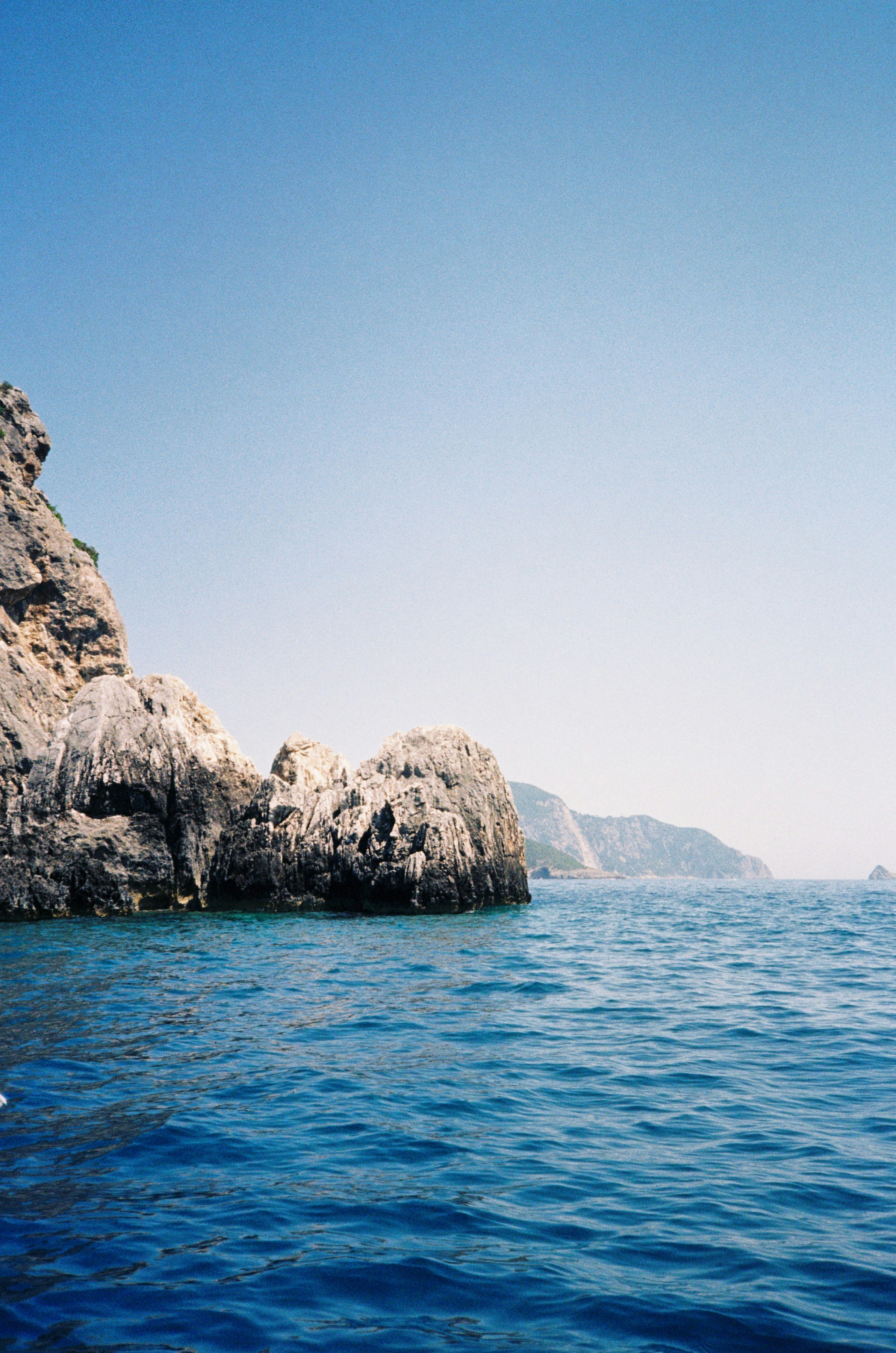 Rugged coastline meeting endless blue: sunlit rocks and open sea