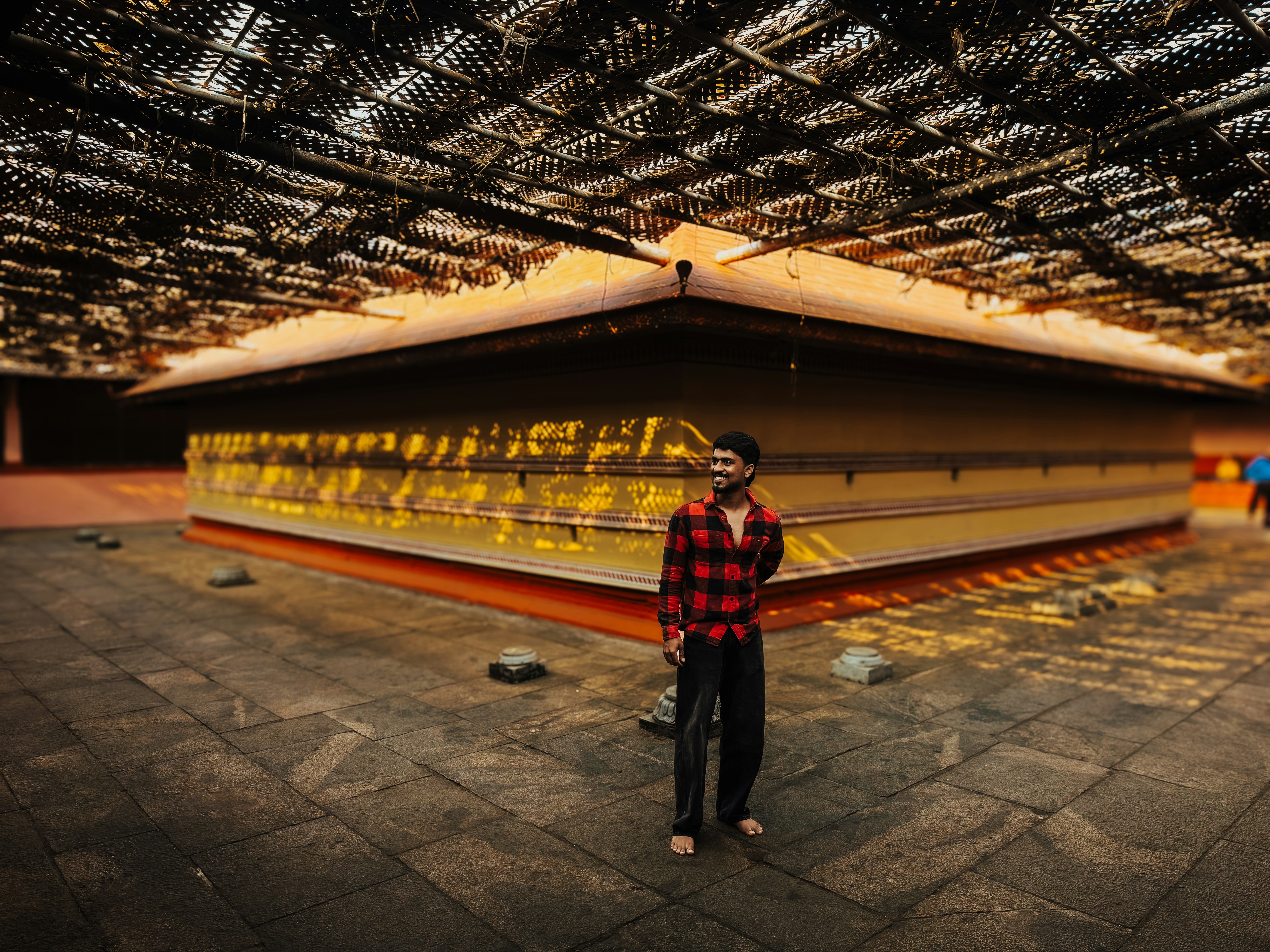 Man in Red Plaid Shirt Beneath a Golden Roof Garden