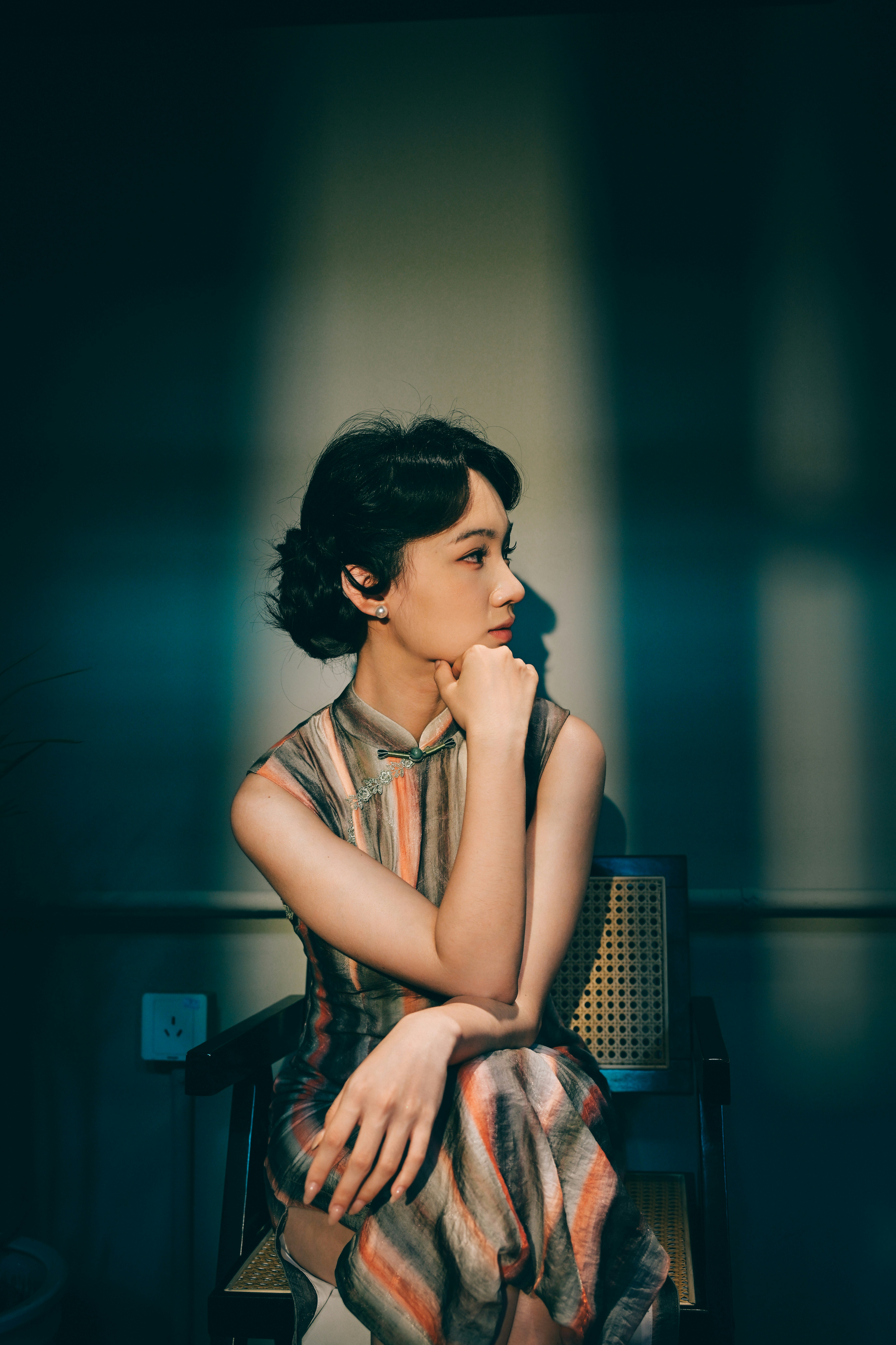 Portrait in Shadowed Spotlight: A Quiet Moment on a Vintage Chair