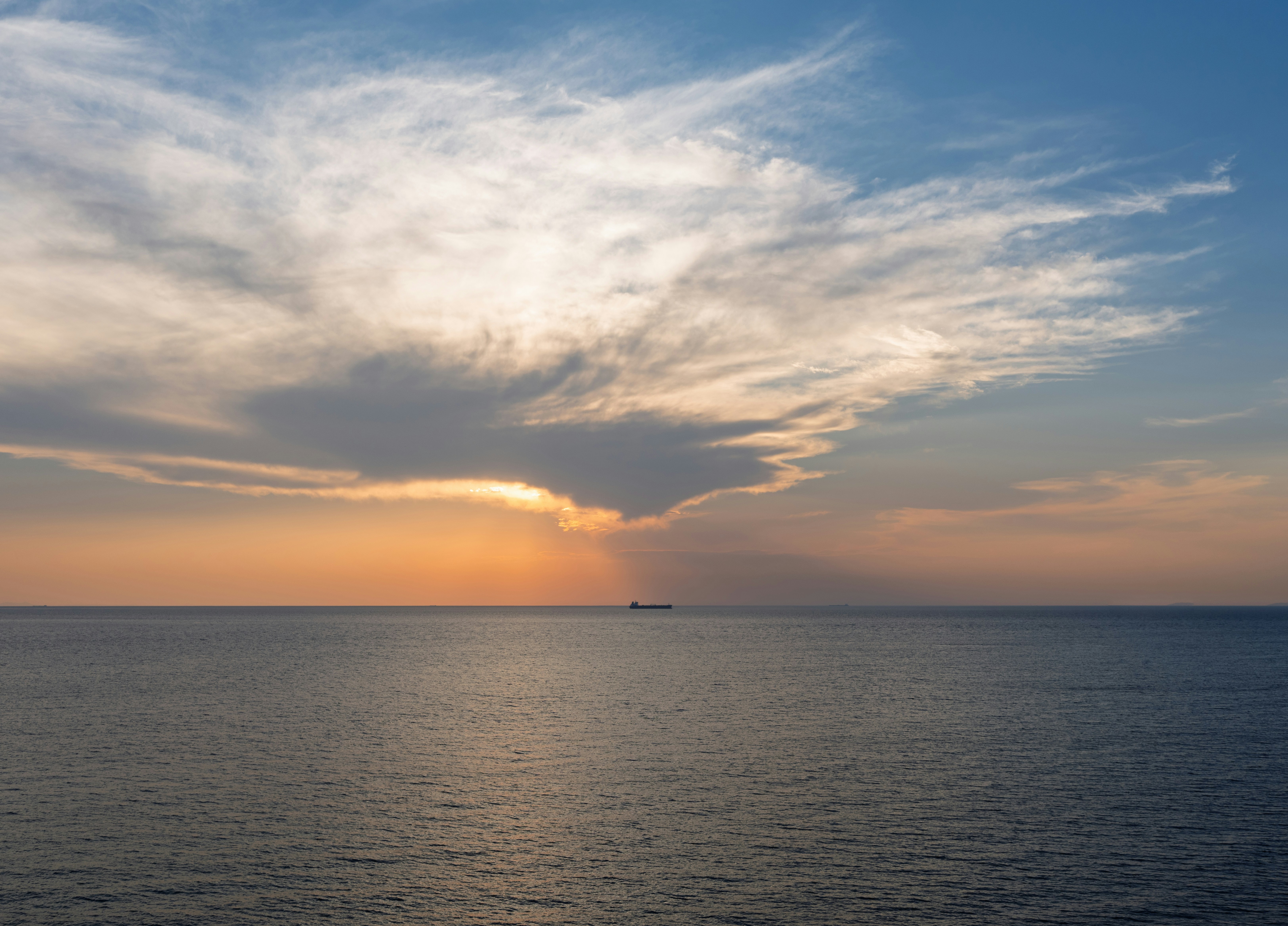 Sunlit Horizon: Quiet Vessel at Dusk