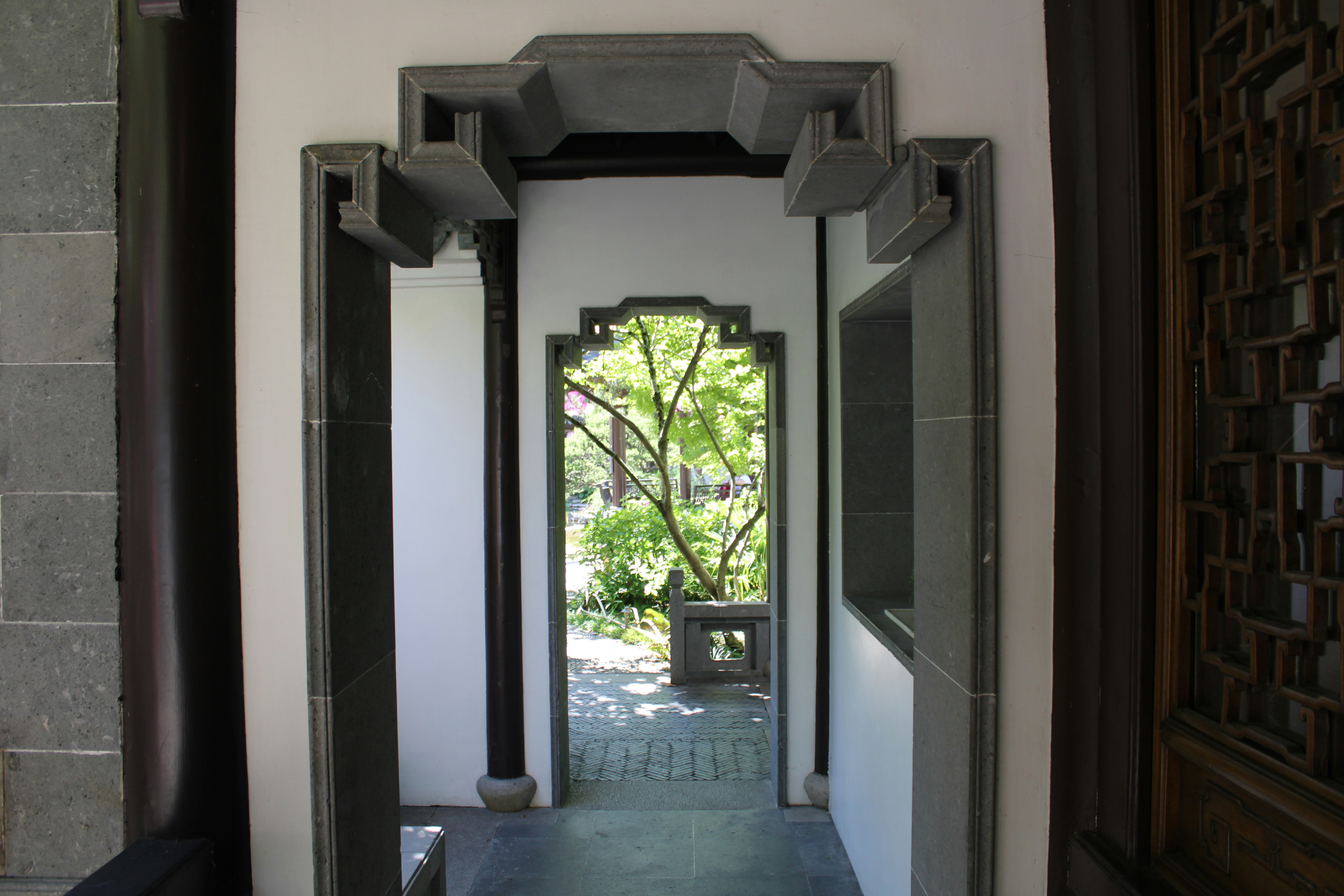 Sunlit Corridor Through Layered Courtyard Gate