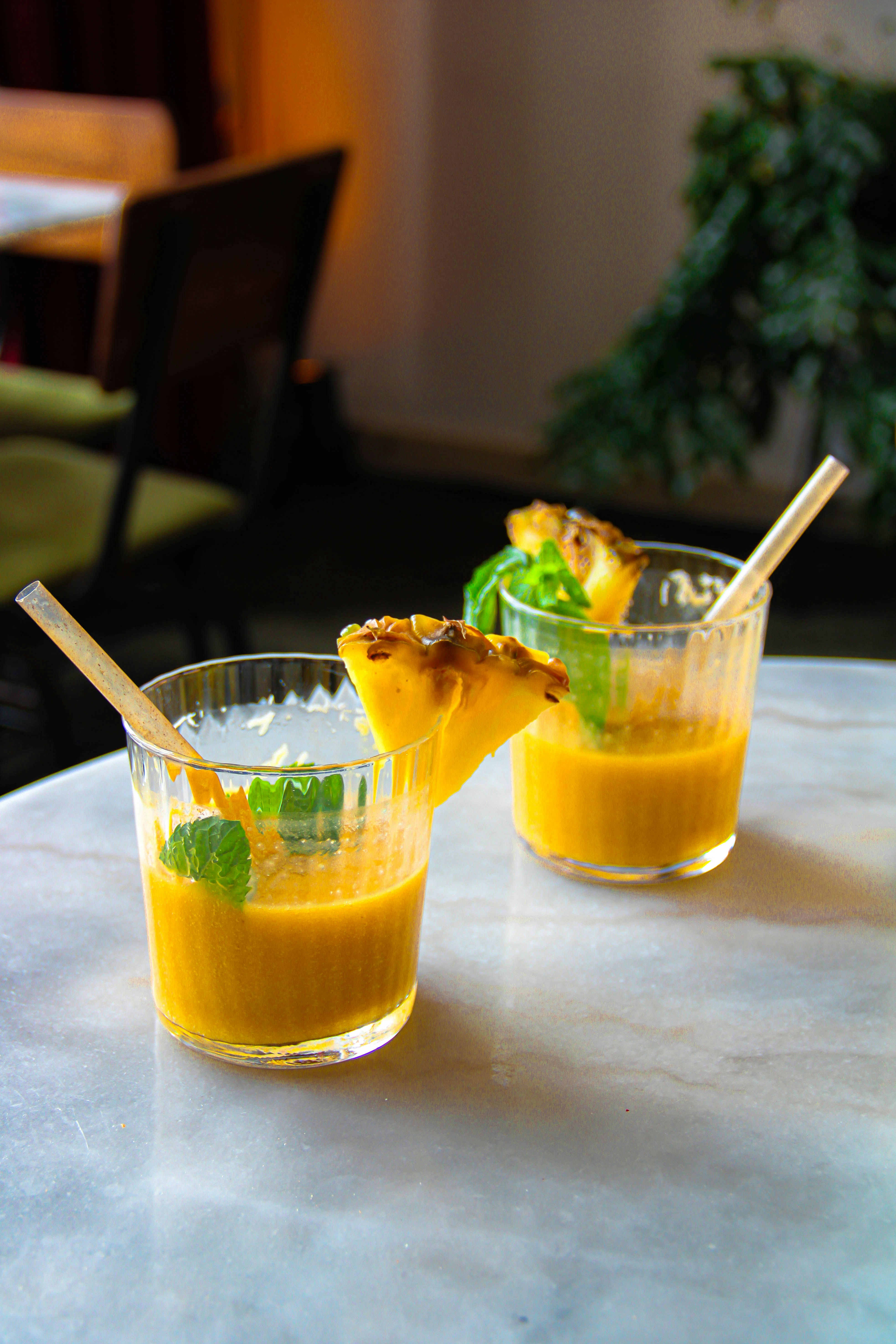 Two Mango Mocktails Framed by a Marble Table and Indoor Ambience