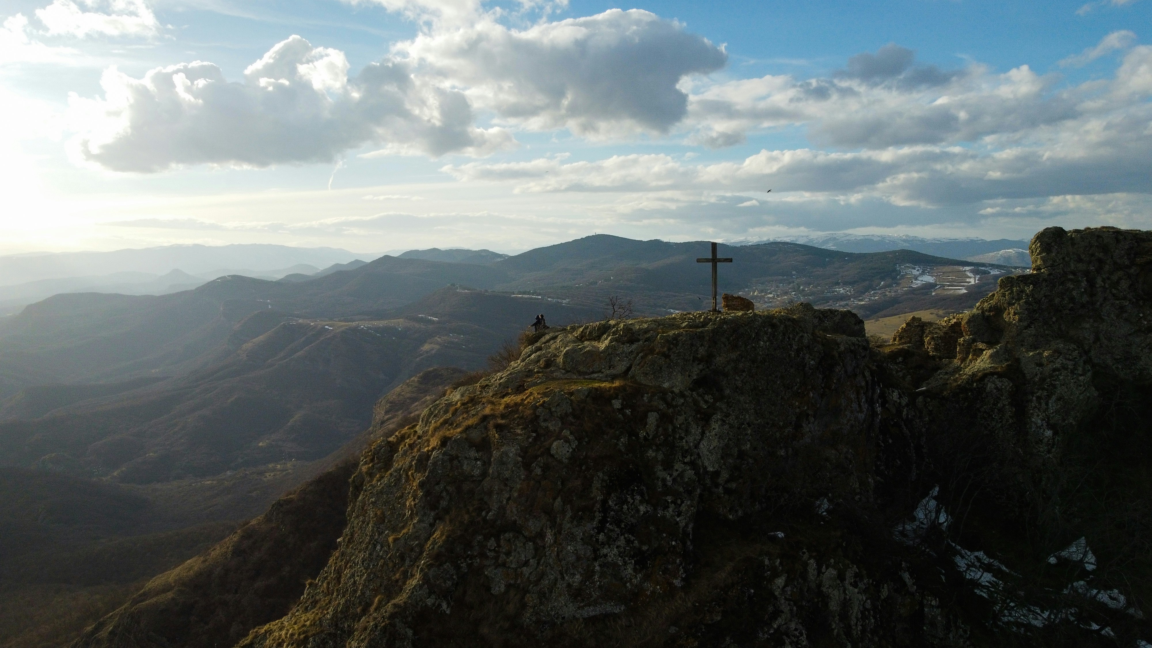 Waypoint at the Ridge: Cross on the Clifftop Overlooking a Valley
