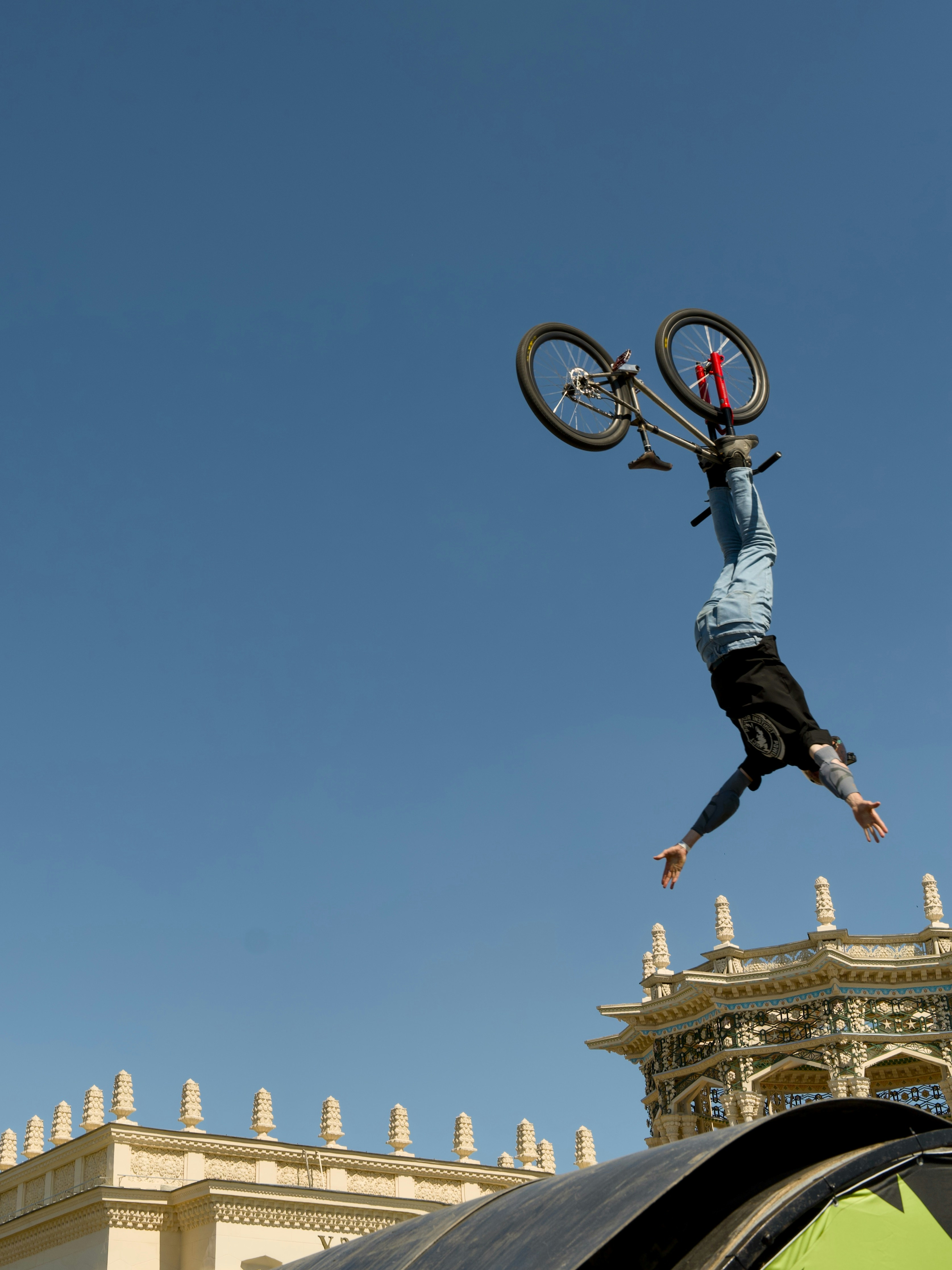 Upside-Down Daredevil: Aerial BMX Acrobat Above Ornate Rooftops