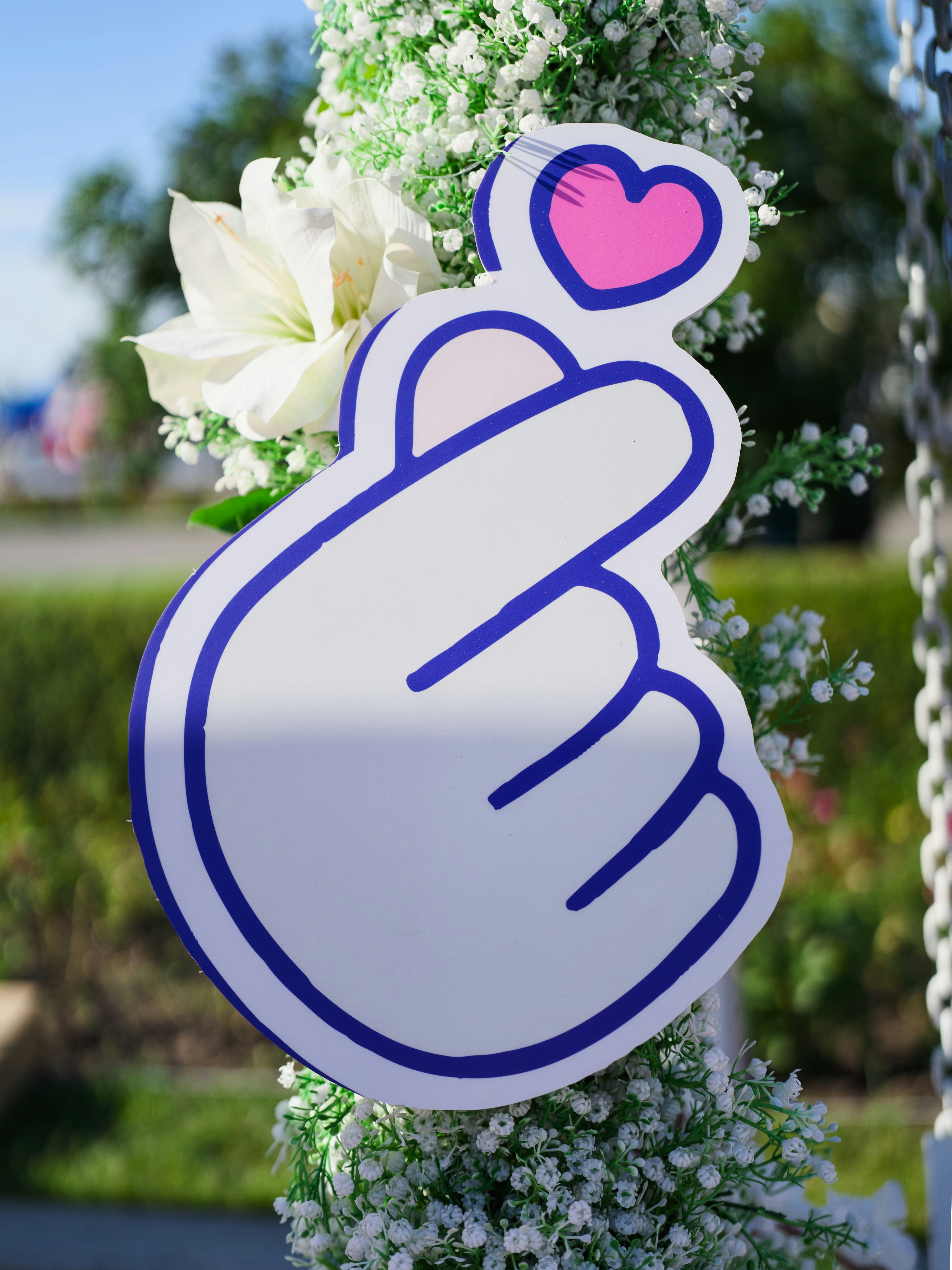 Thumbs Up Love: A Flower-Decorated Signpost in Bloom