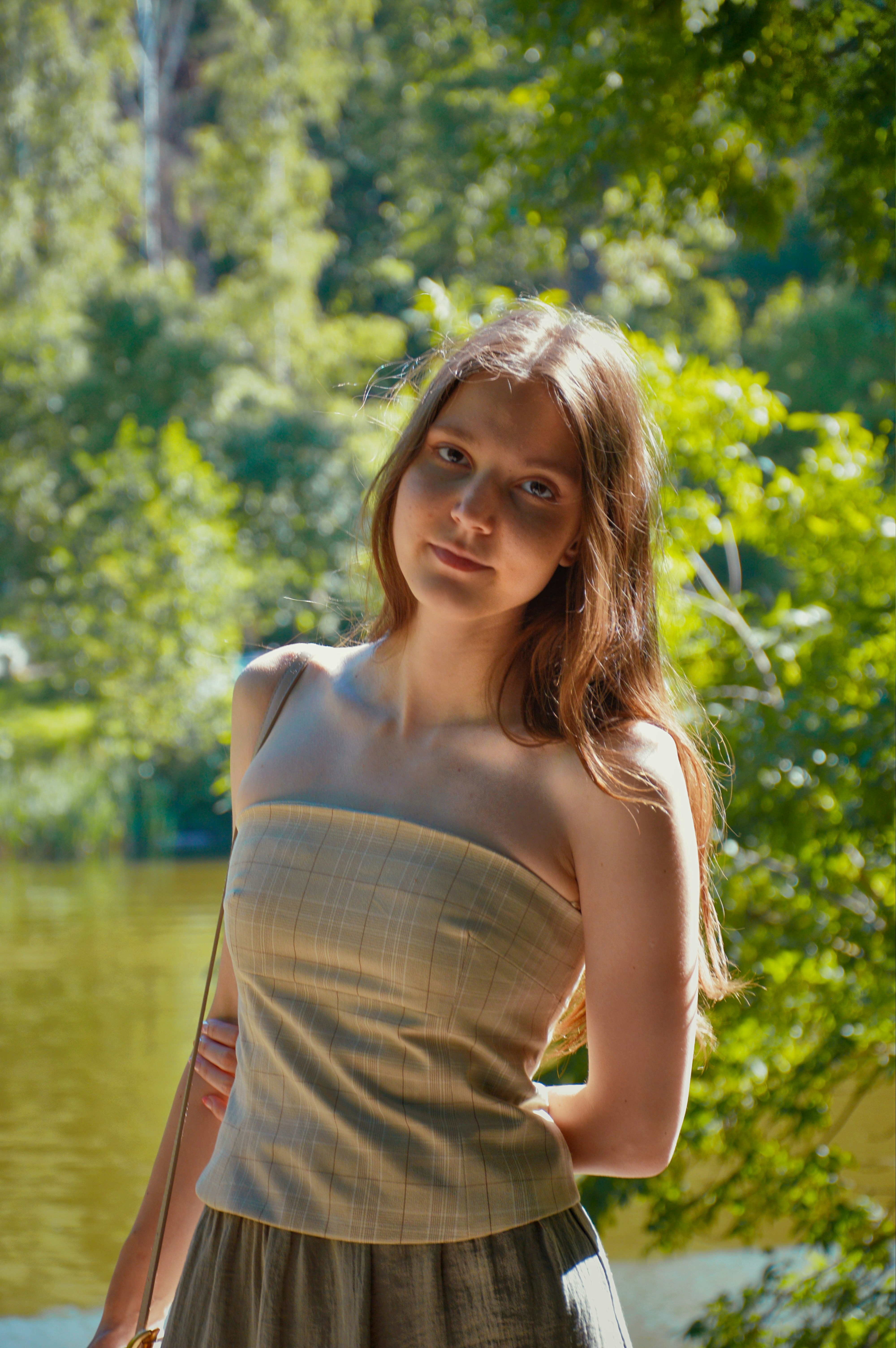 Soft sunlight, clear gaze: Portrait in a sunlit riverside garden