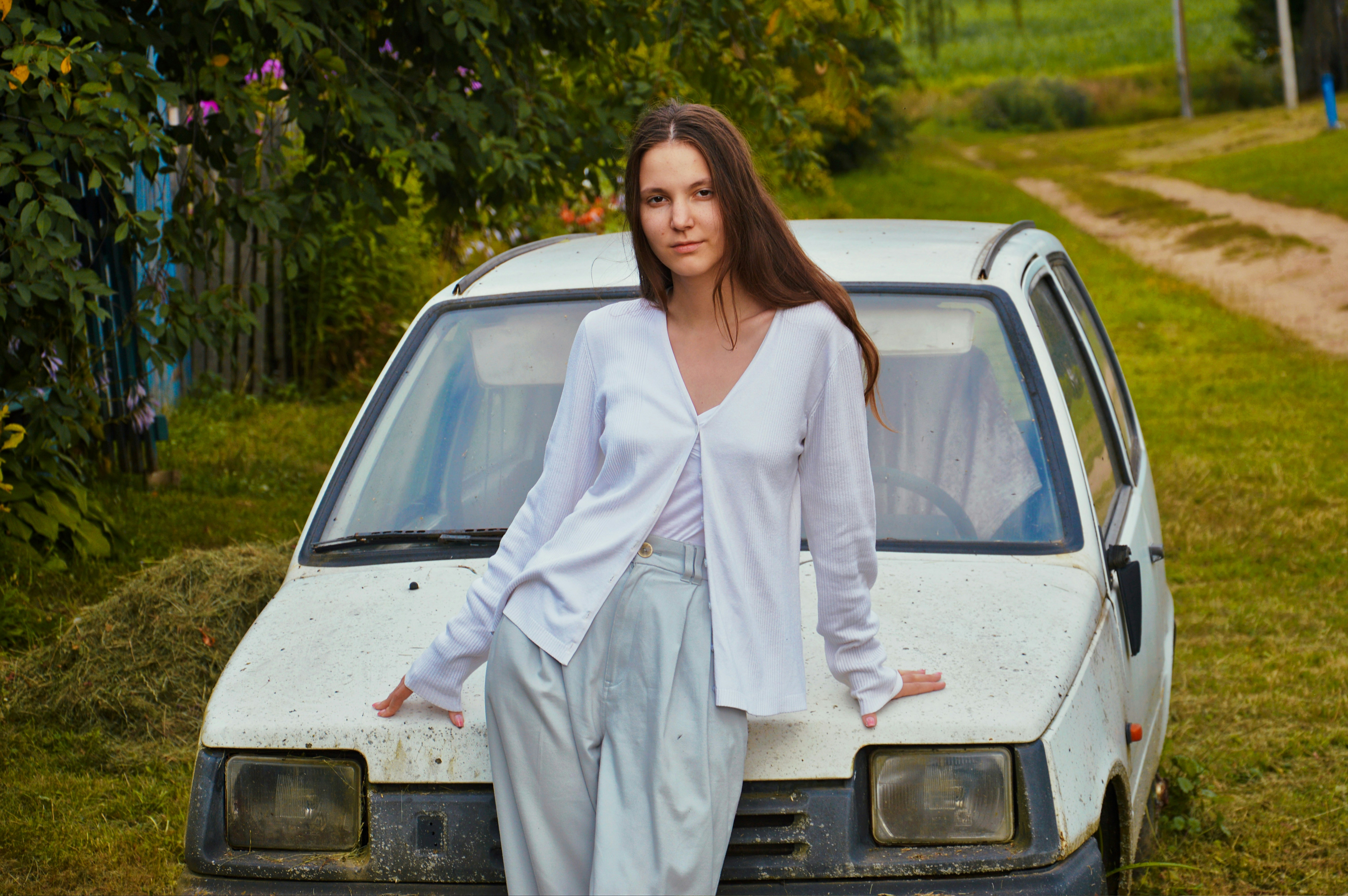 Portrait by a Weathered Car: Quiet Confidence in a Rural Lane