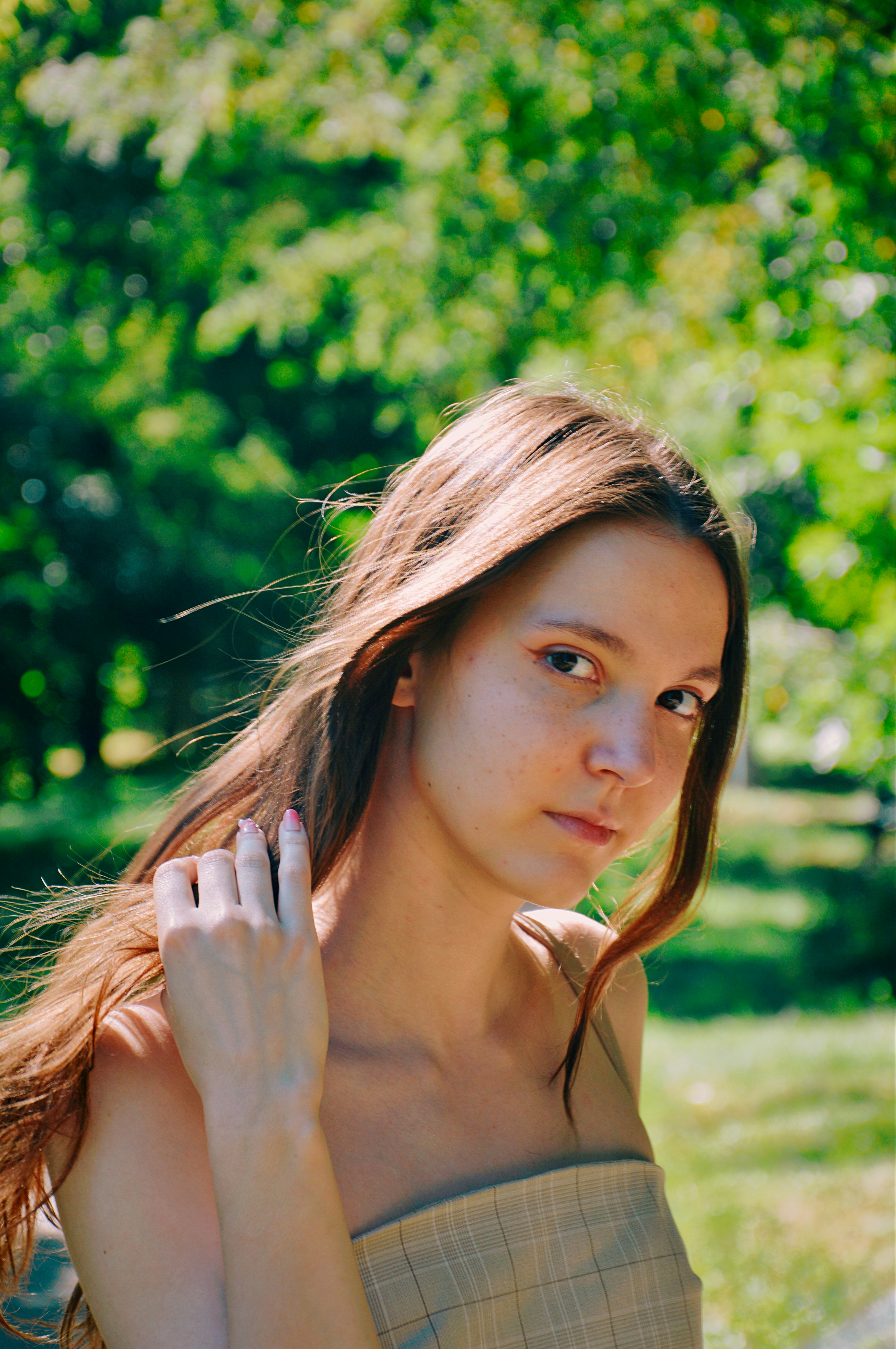 Portrait in Sunlit Park: Soft Focus and Warm Light on a Youthful Gaze