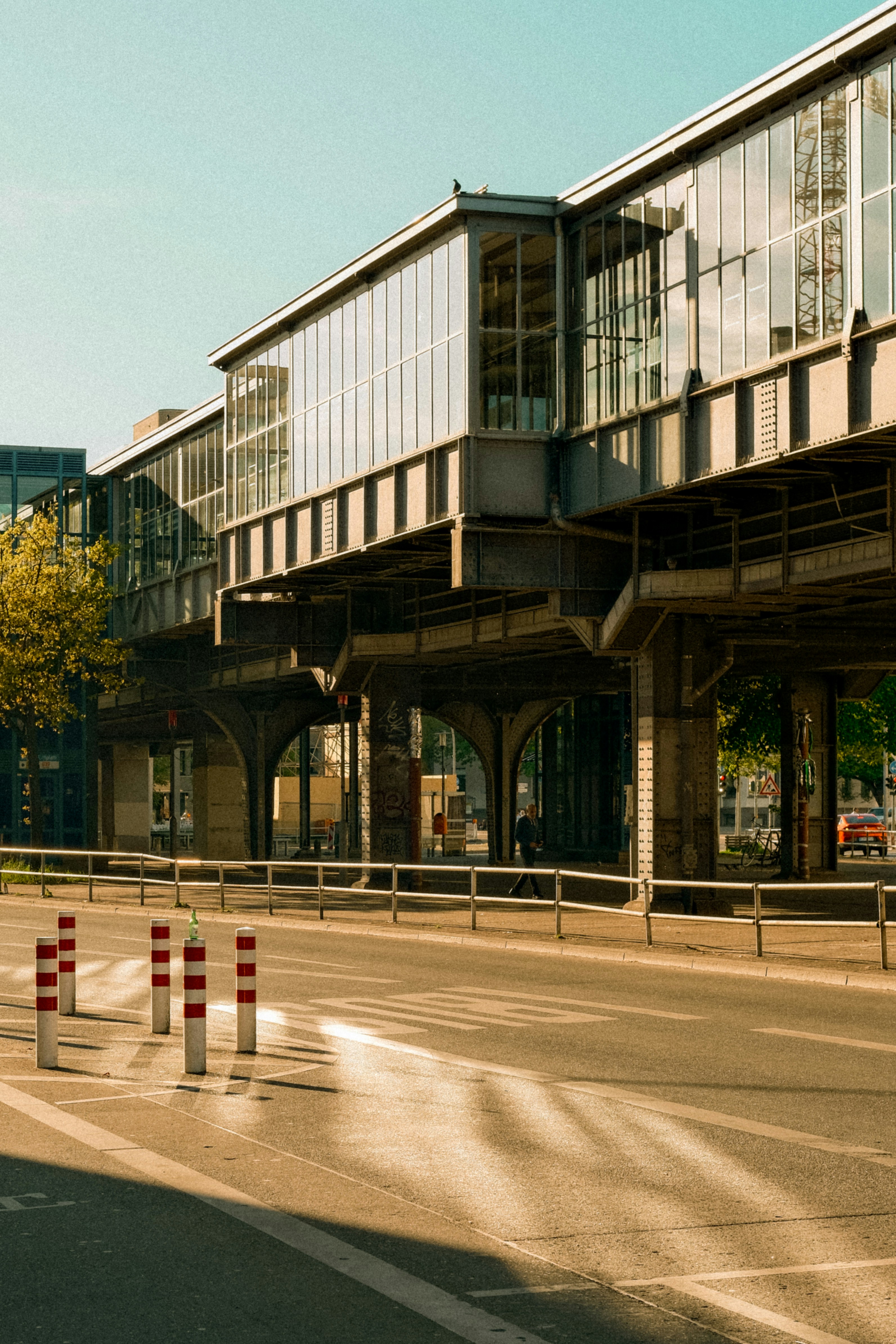 Elevated Glass Corridor Overpass Framed by Street Level Arcades