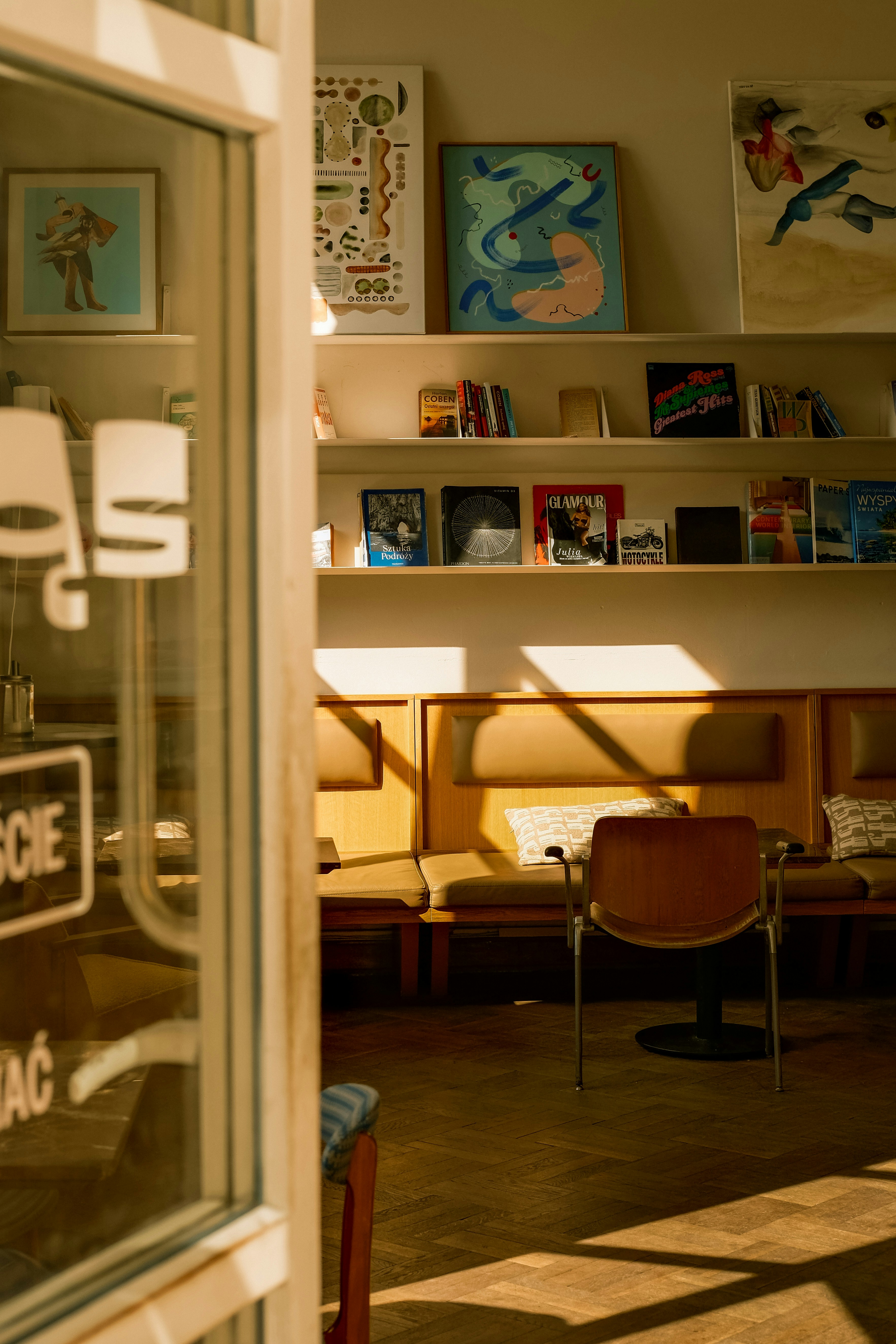 Sunlit interior of a cozy bookstore cafe with wall art and mid-century seating