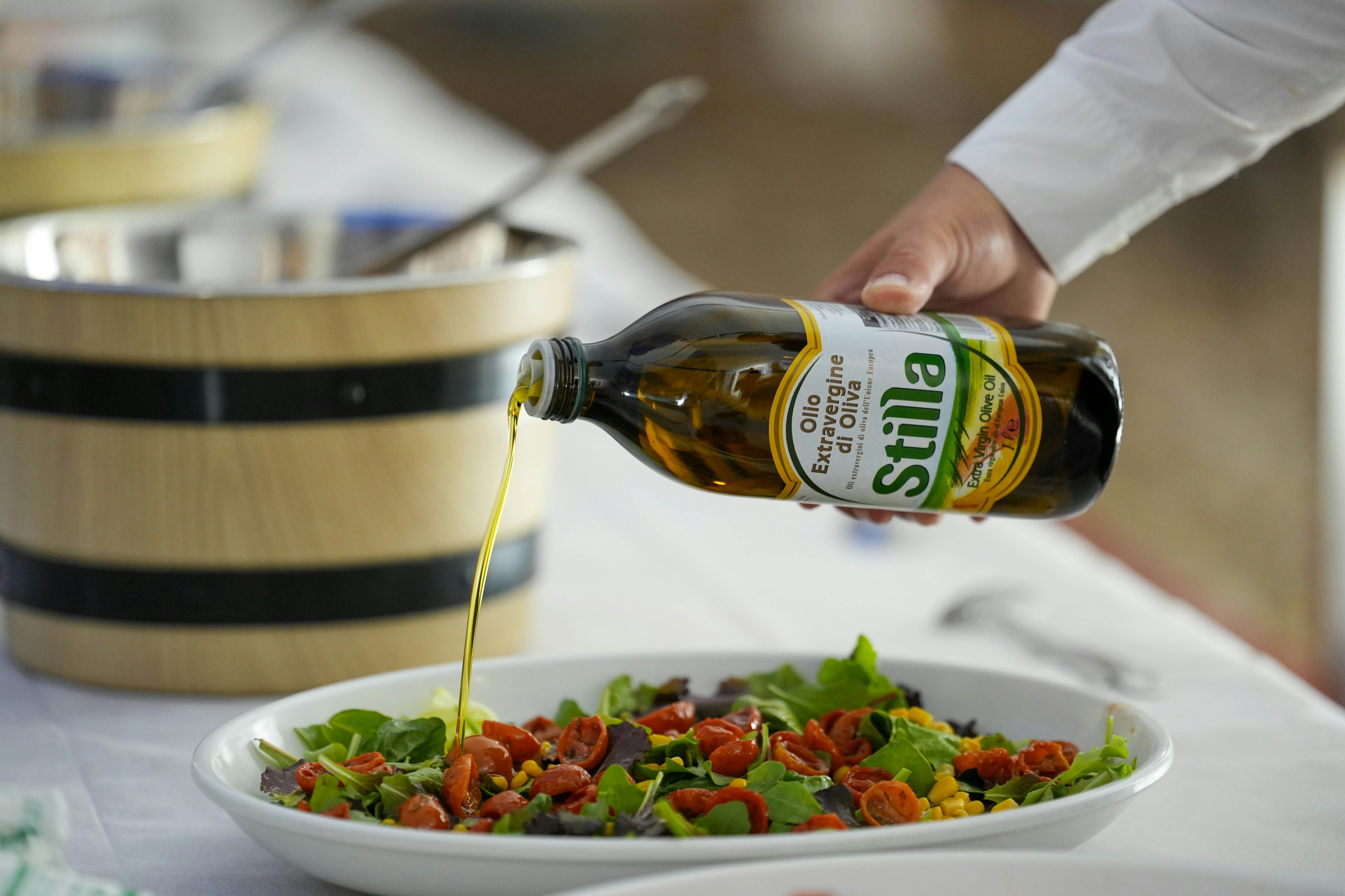 Golden Drizzle: Olive Oil Cascade Over a Vibrant Salad