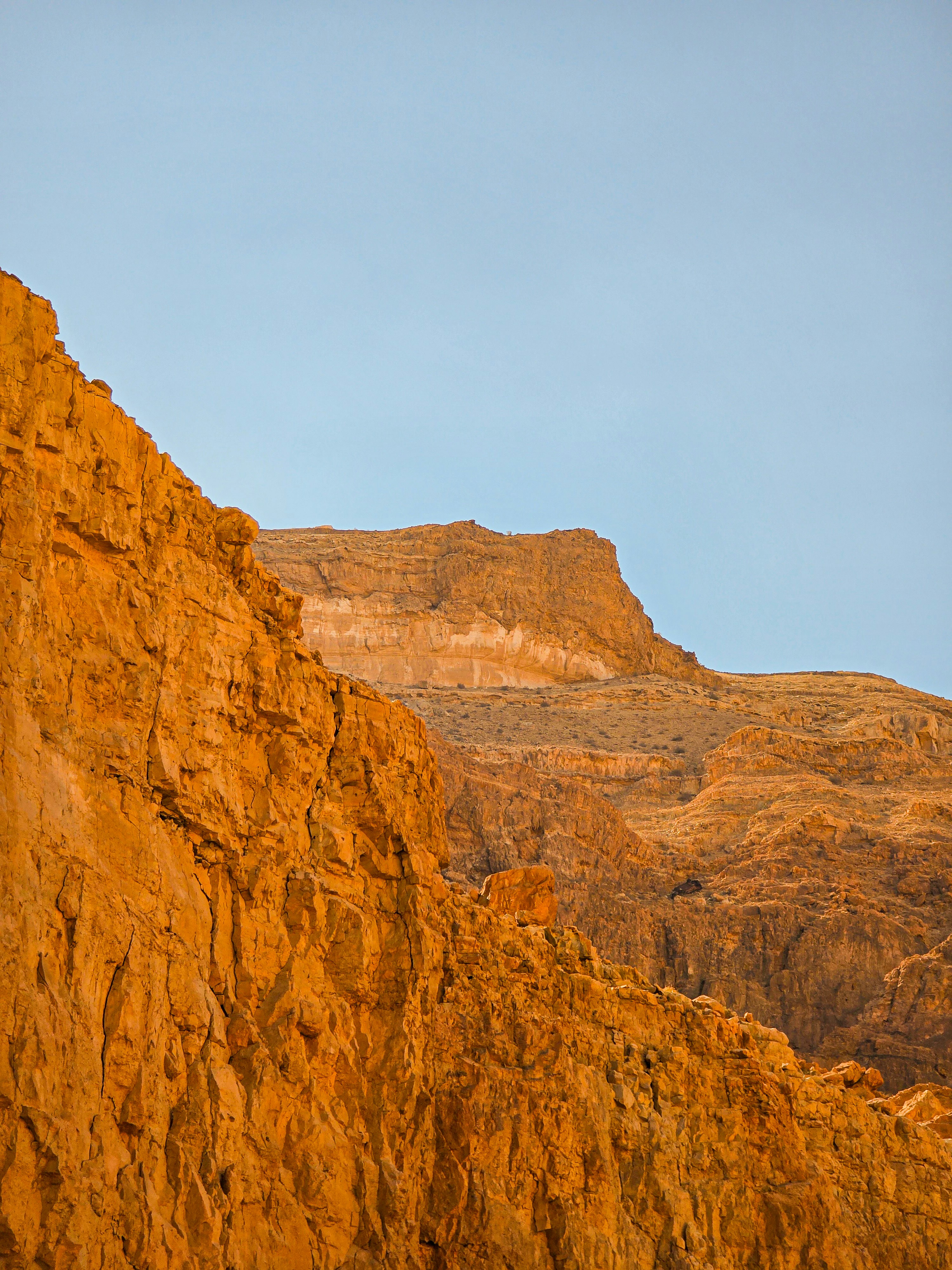 Golden Ridge: Sunlit Cliffs Against a Clear Sky