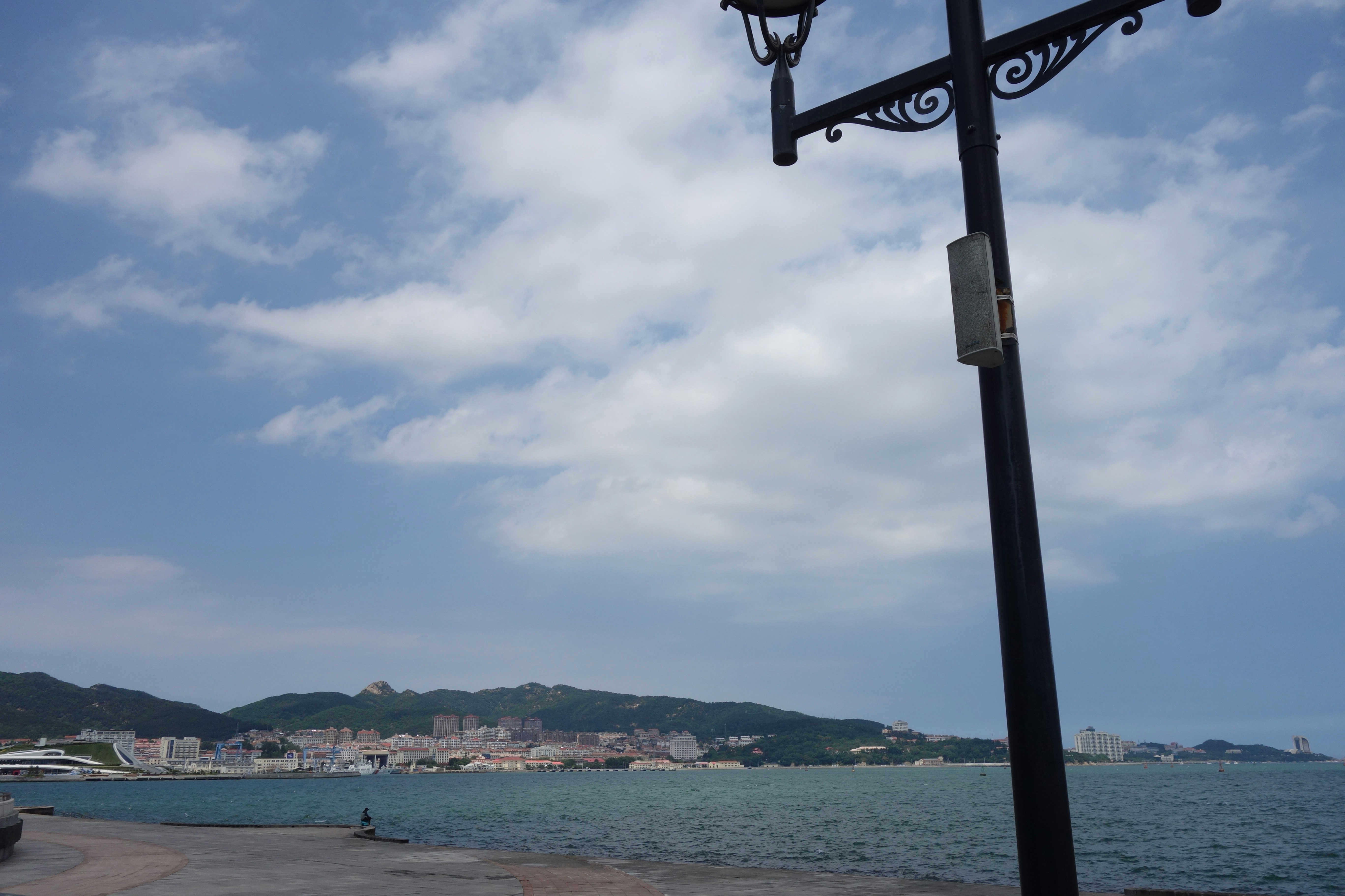 Lantern Over the Seafront: A Quiet Harbor Under Blue Skies