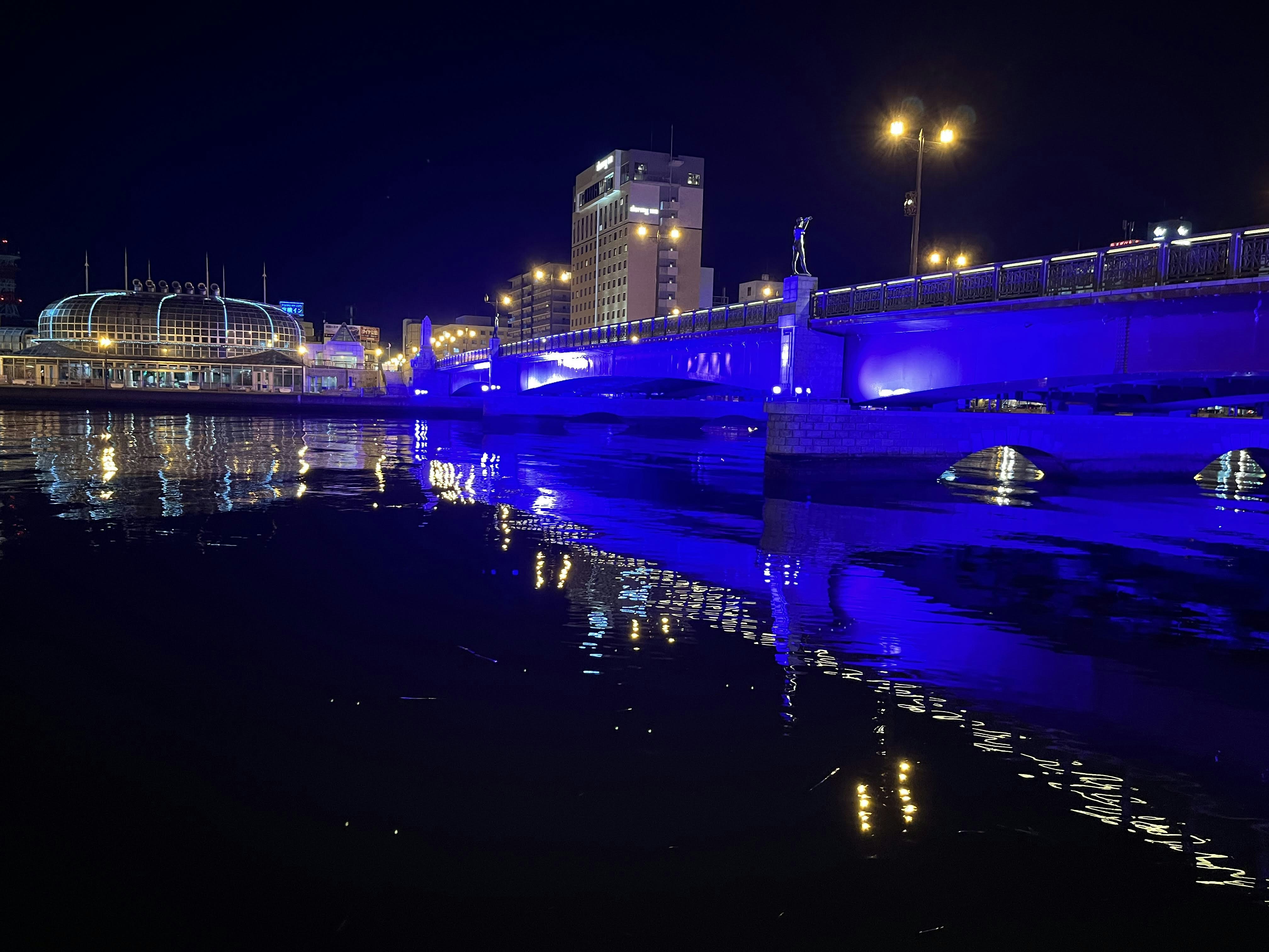 Blue Night Run: Neon Bridge Over Reflected Water