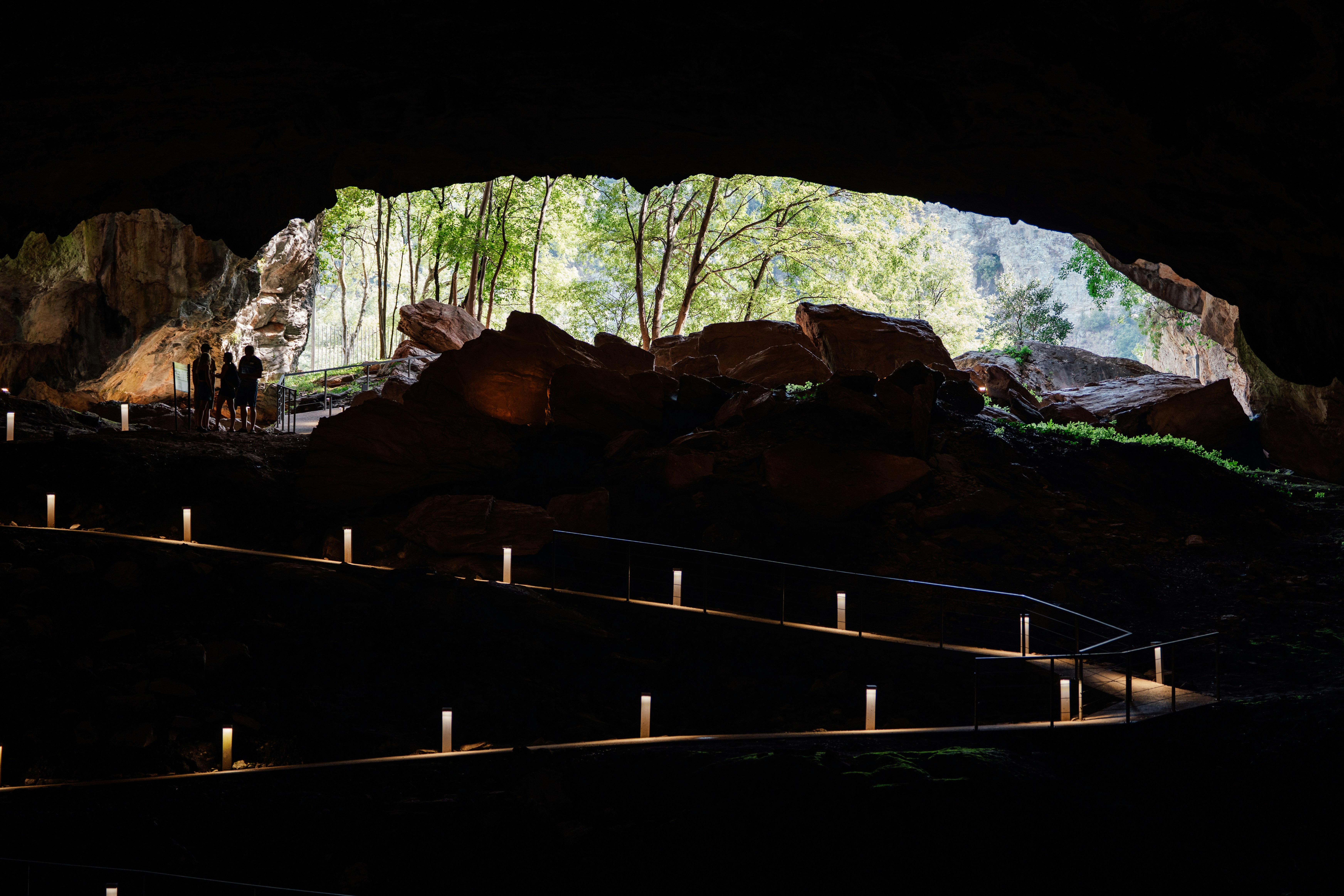 Lantern-lit Path through a Shadowed Cave