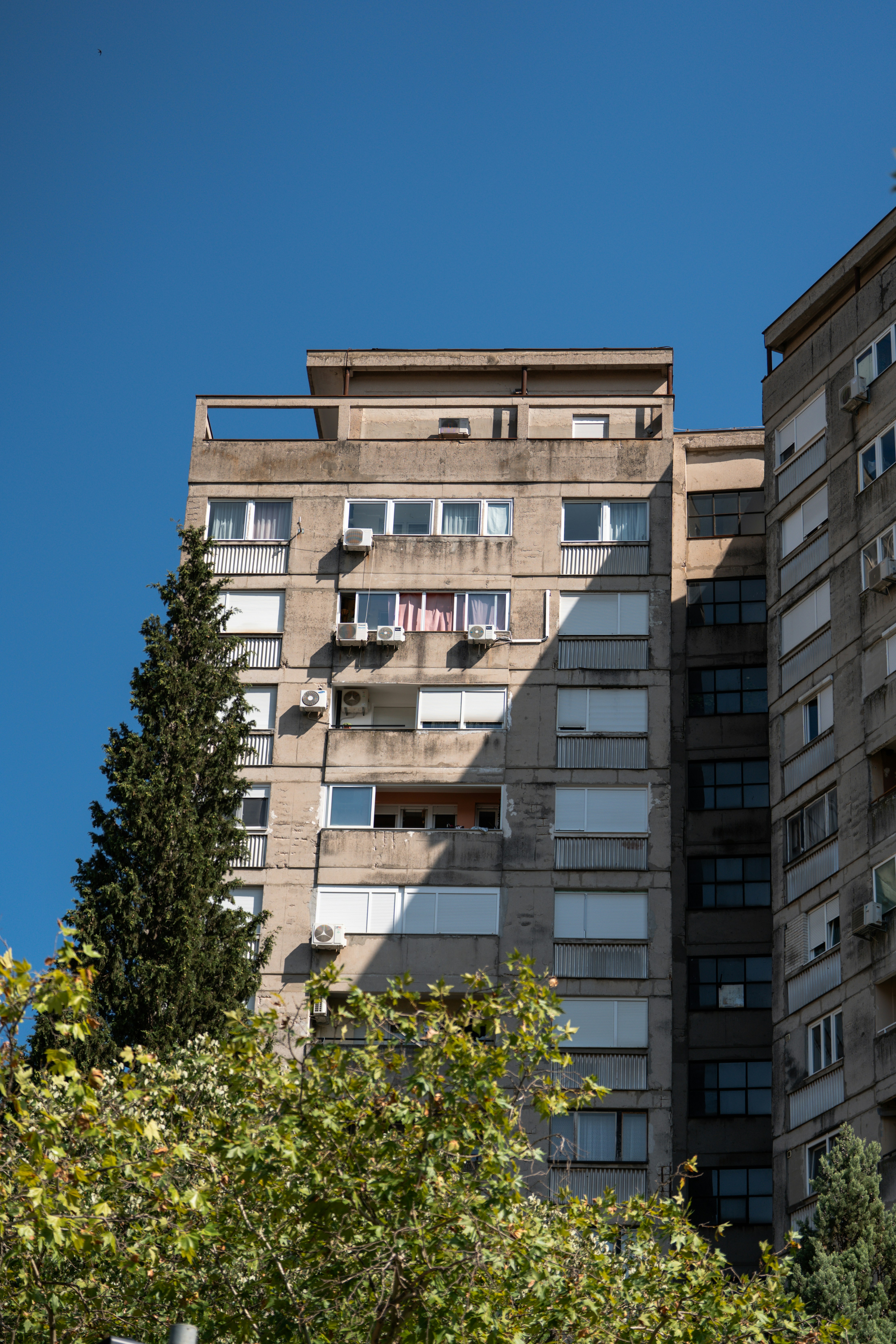Concrete Skyline: A Tall Apartment Stack Reaches Toward the Clear Blue