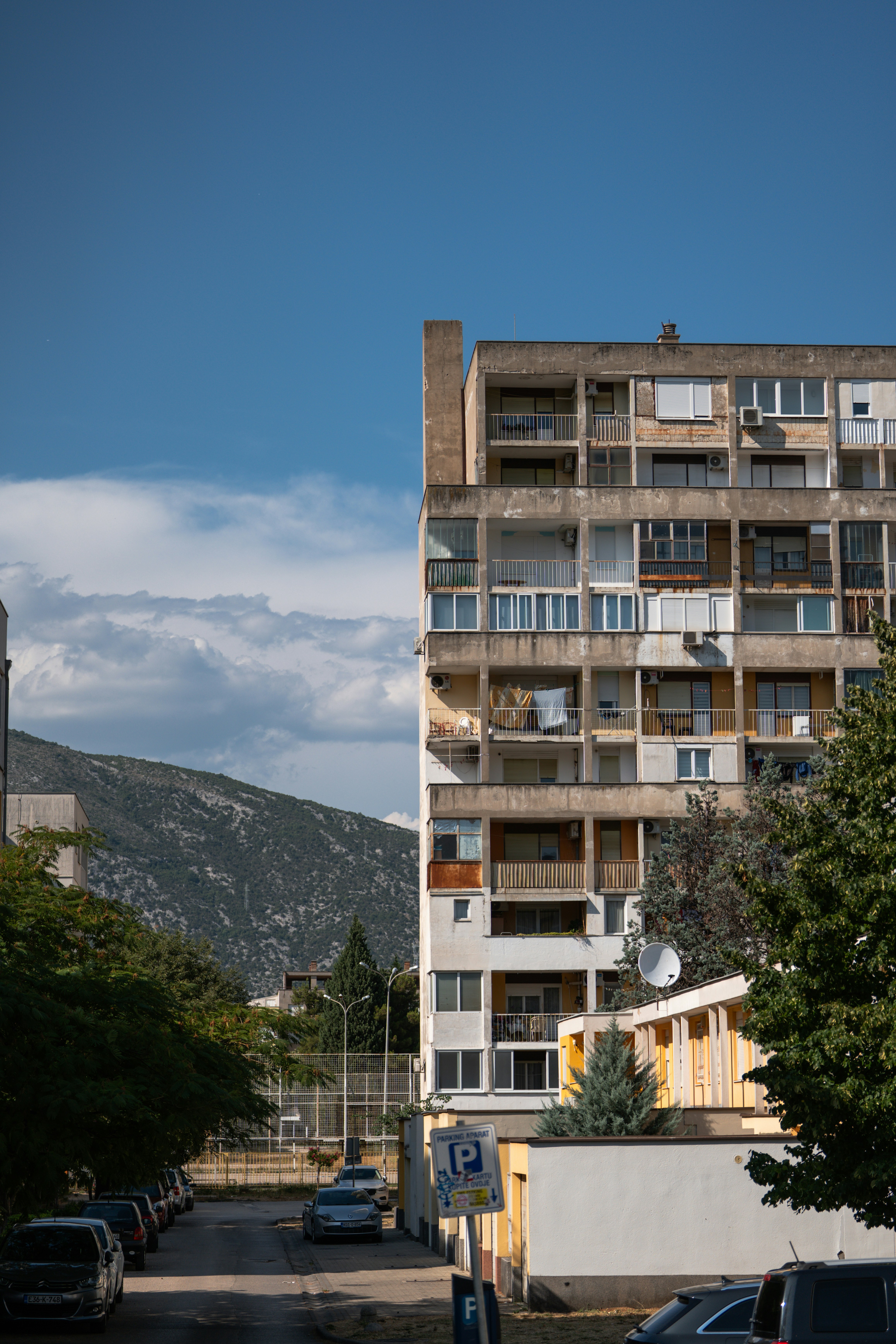 Facade of a Weathered Apartment Block with Mountain Backdrop