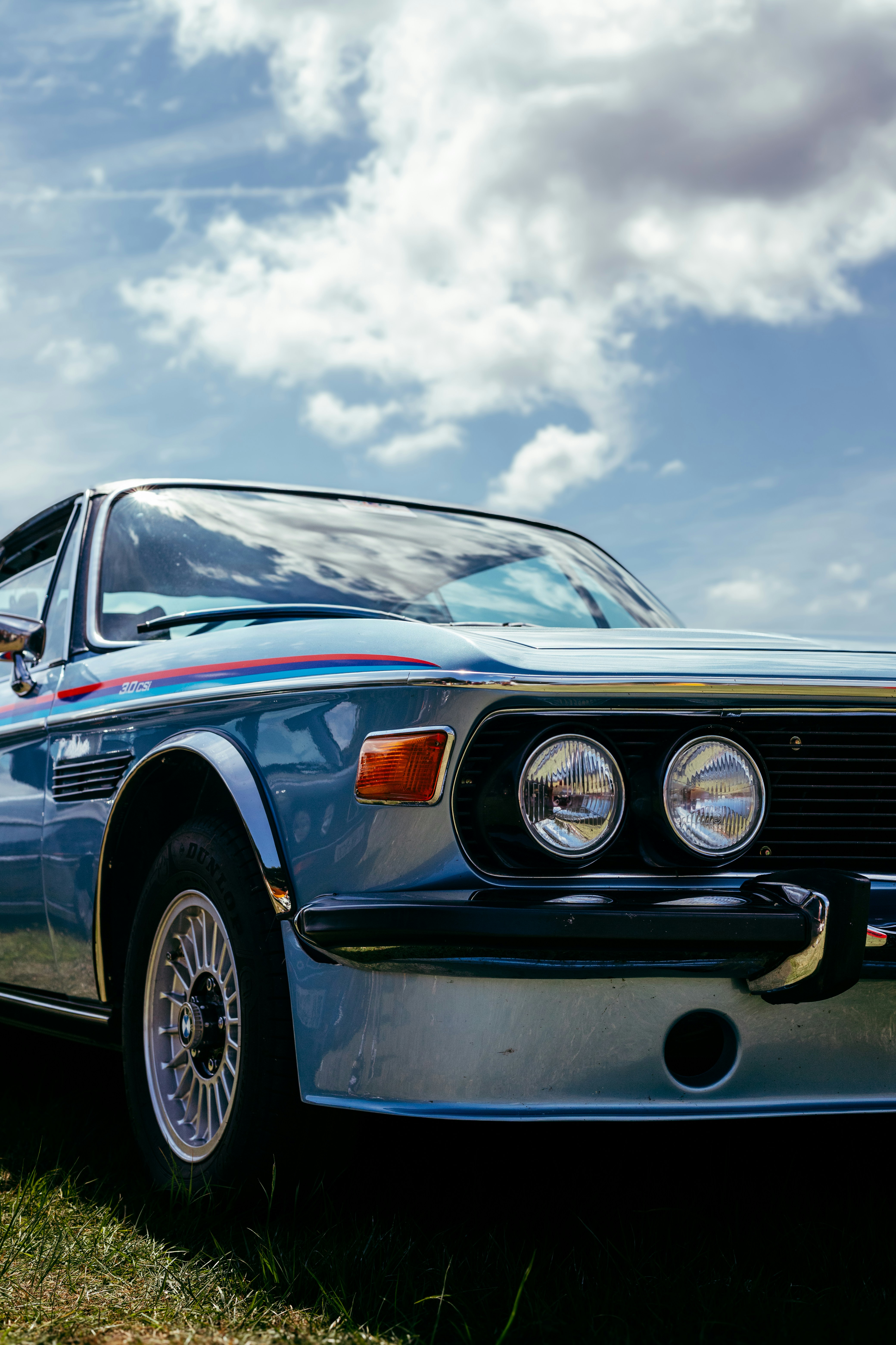 Blue Classic: The Front-Hedge of a Vintage BMW in Sunlit Grassy Field