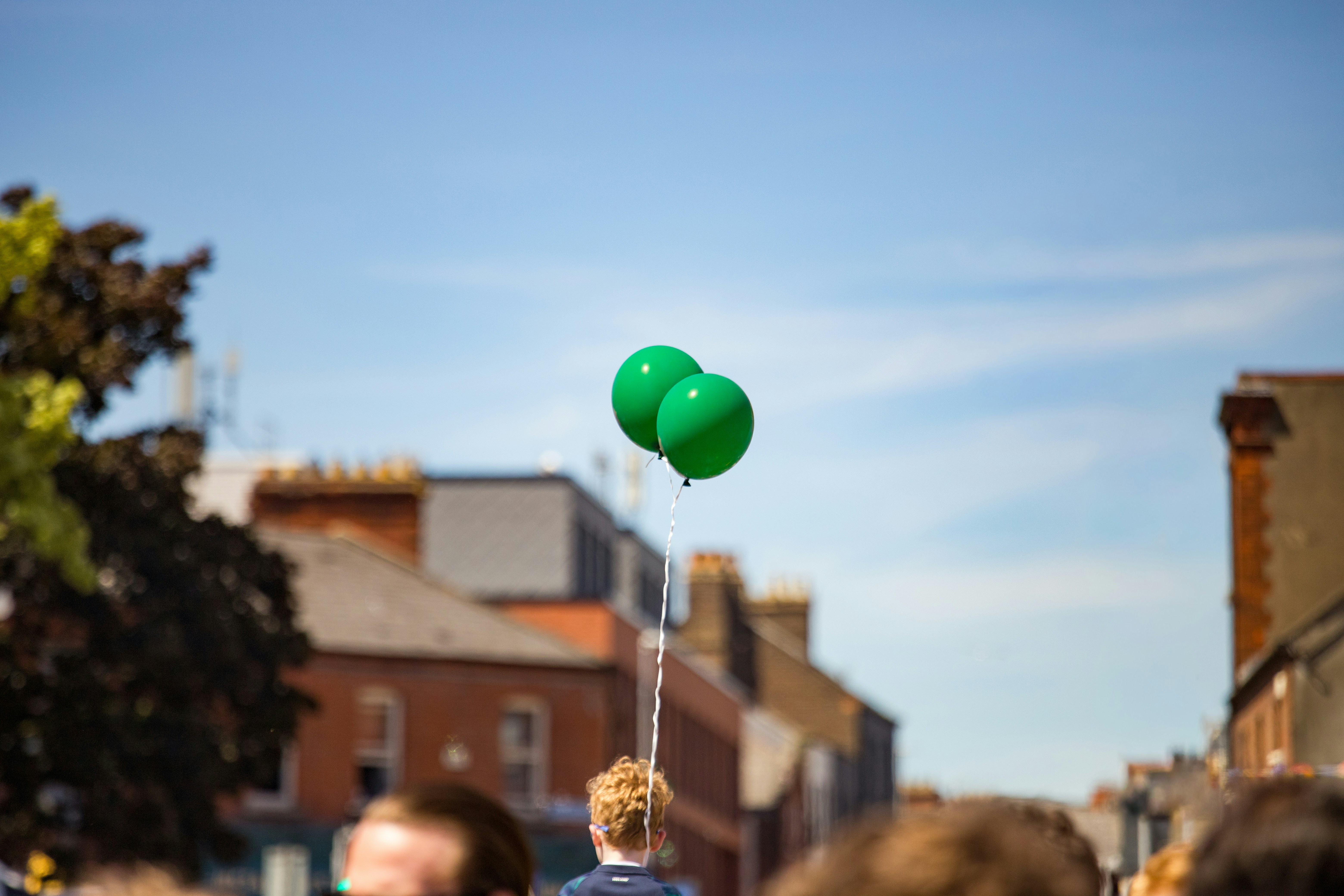 Ballooned Sign of Hope Above a Crowded Street