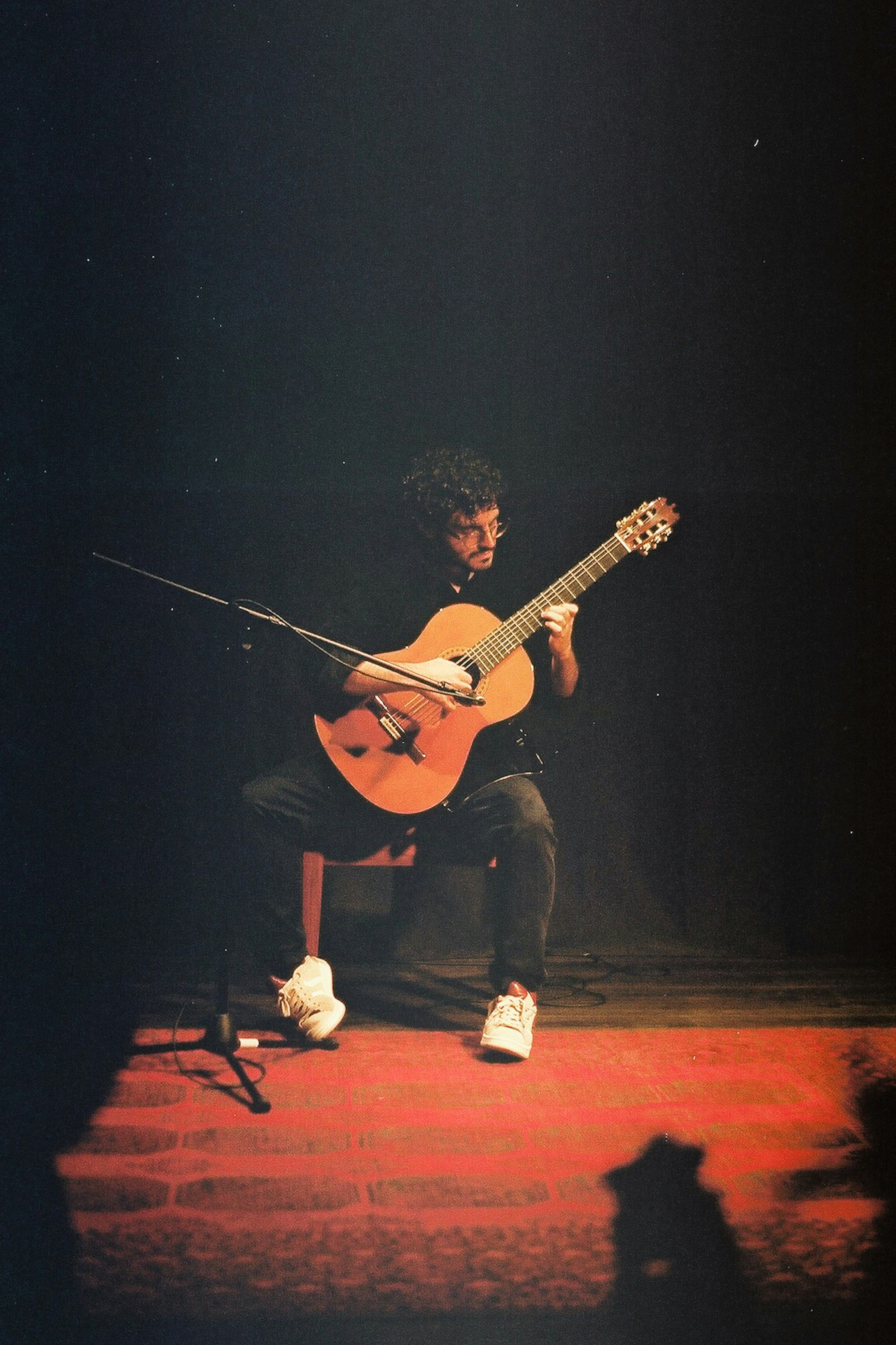 Guitarist in a Dim Spotlight: Strings of Silence on Stage