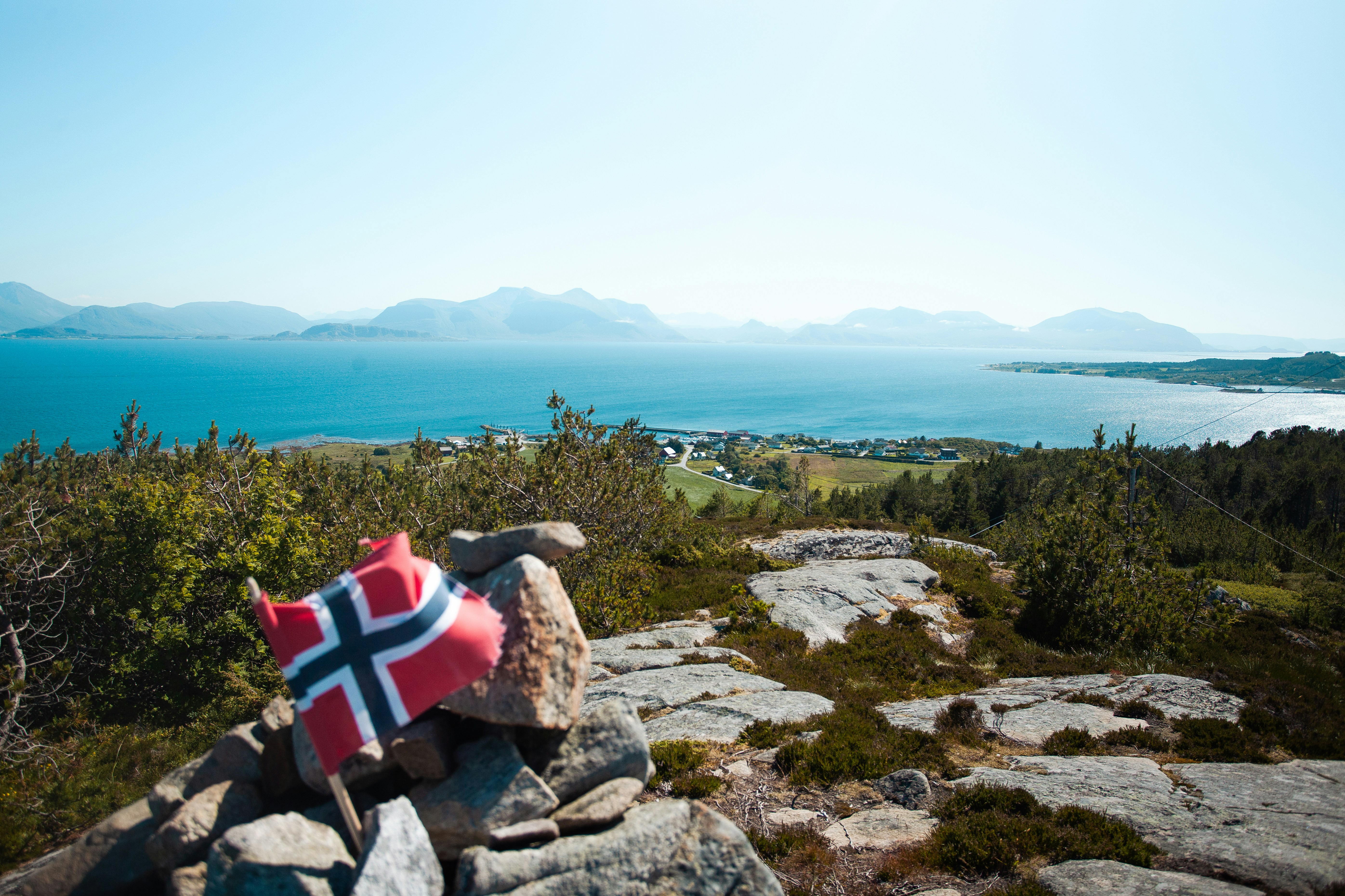 Norwegian Sea View: Flag and Stone Marker at Coastal Outlook