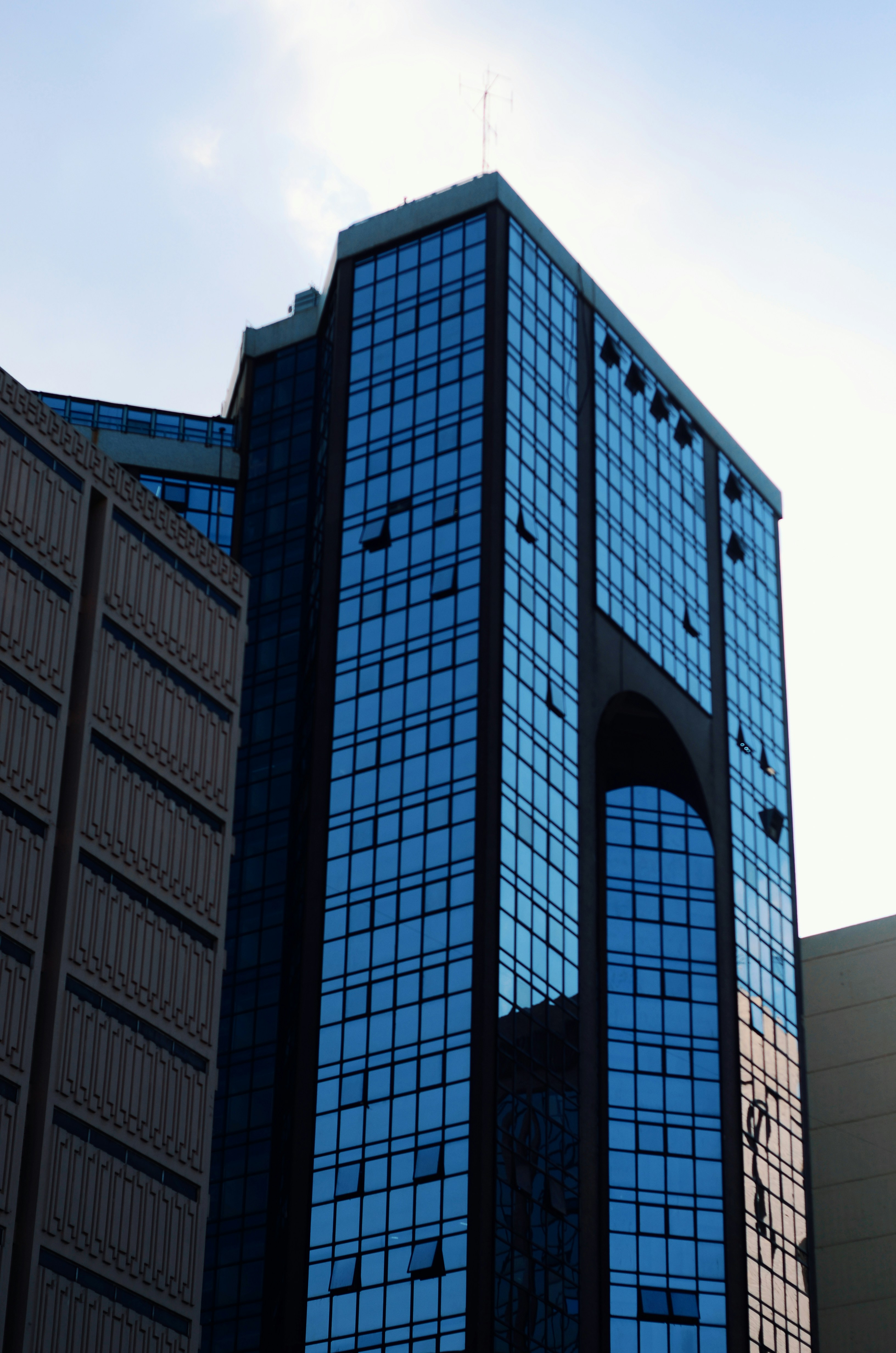 Vertical Mirror: A Blue Glass Skyscraper Rising Against the Sky