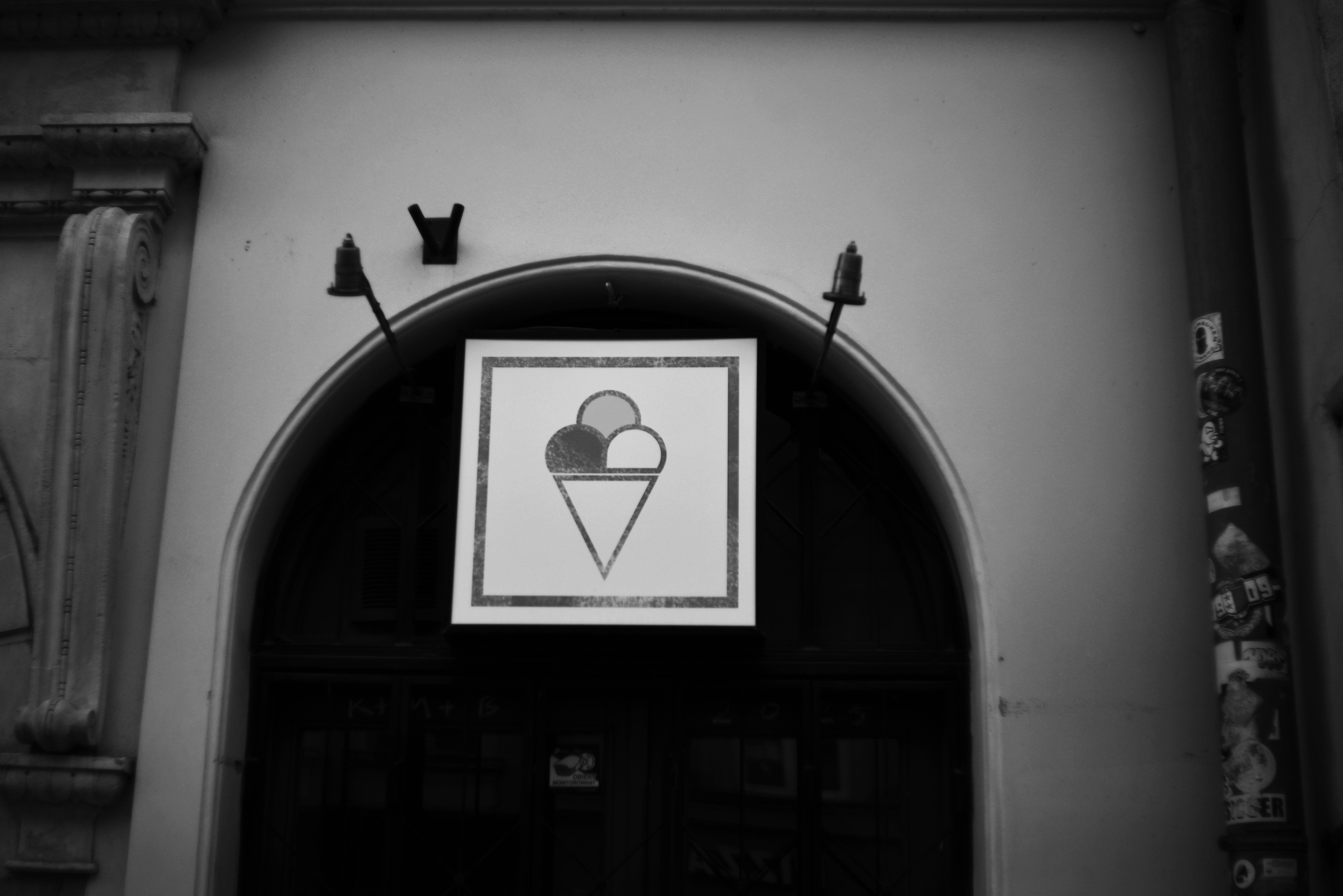 Arched Facade Signage: Monochrome Freeze Above the Door