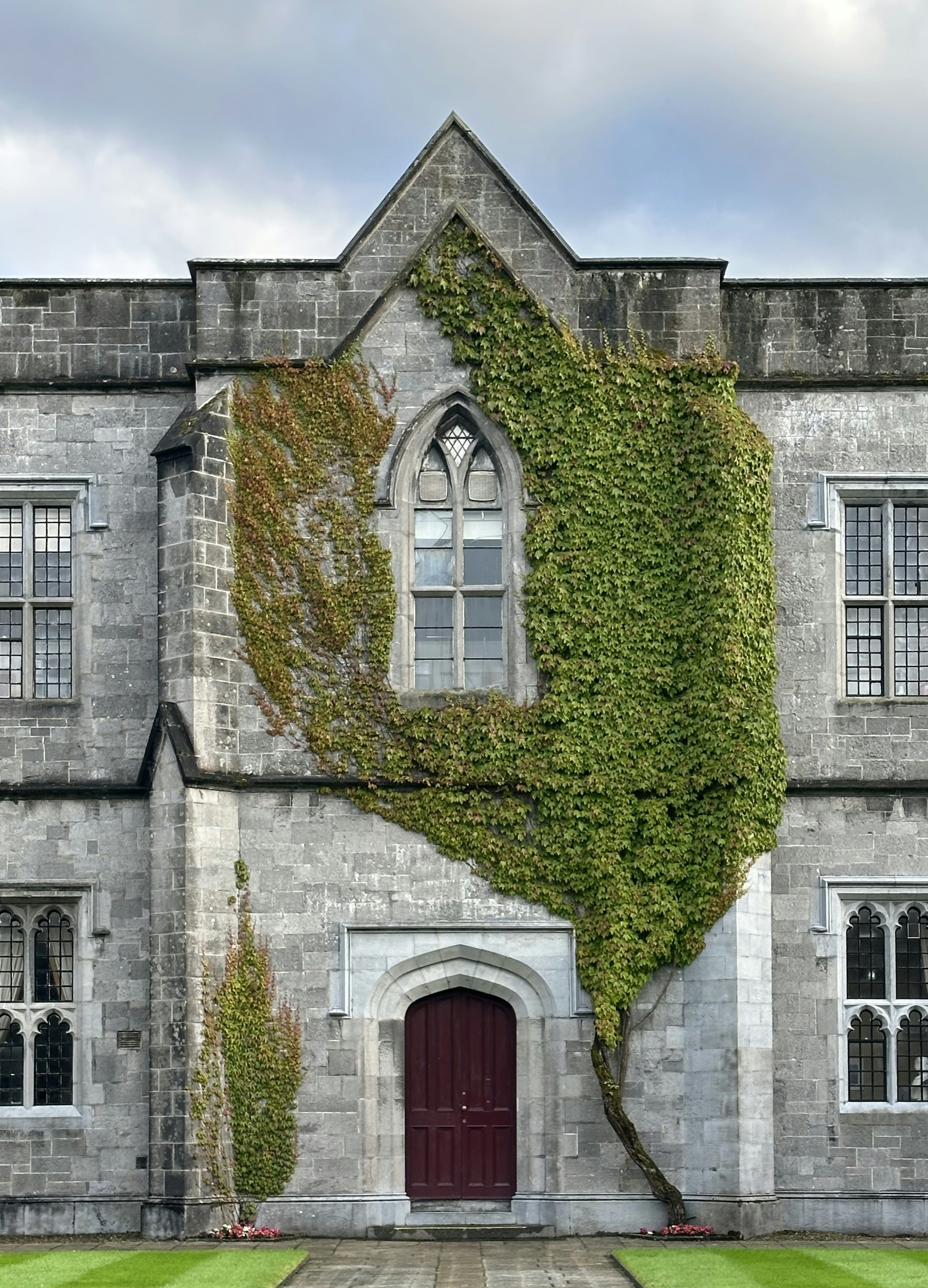 Ivy-Clad Gothic Facade Guarding the Red Door