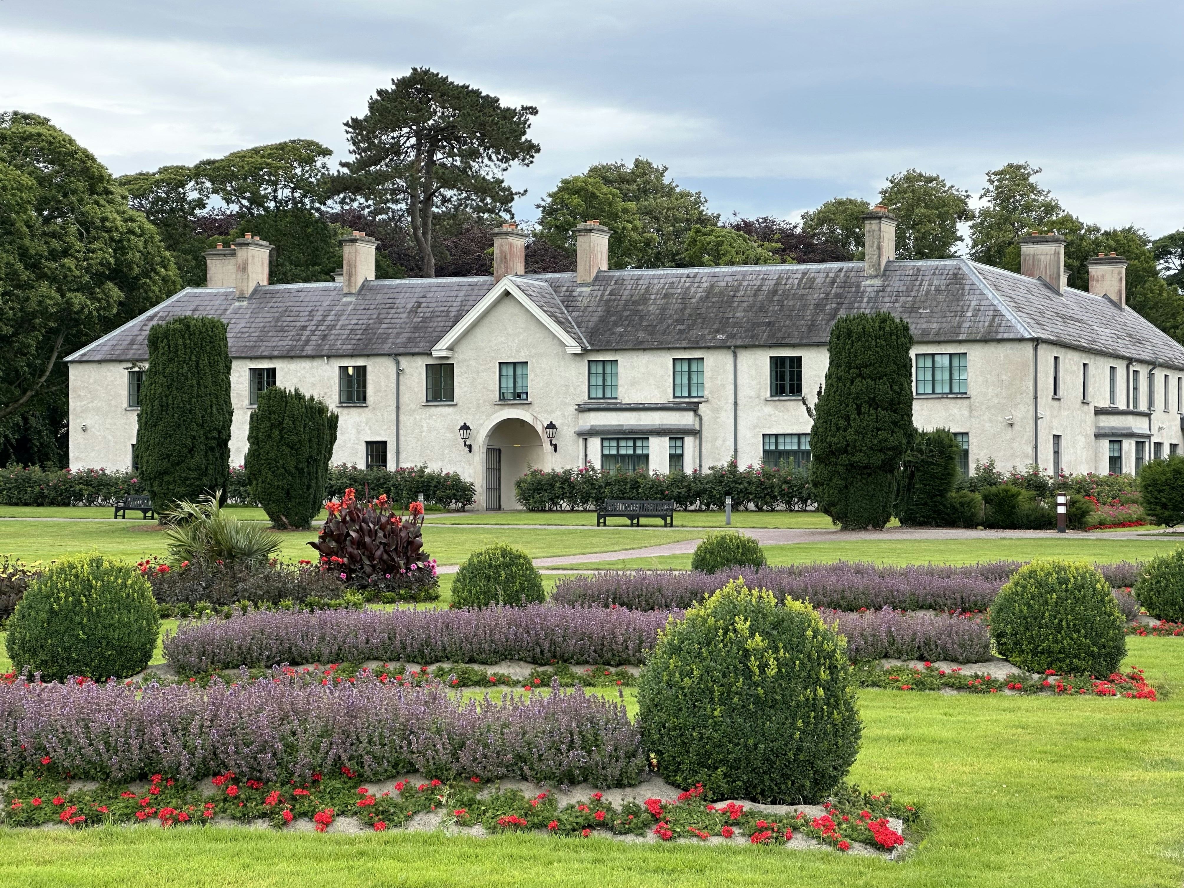Formal Estate in Bloom: A Neatly manicured garden Leads to a stately manor