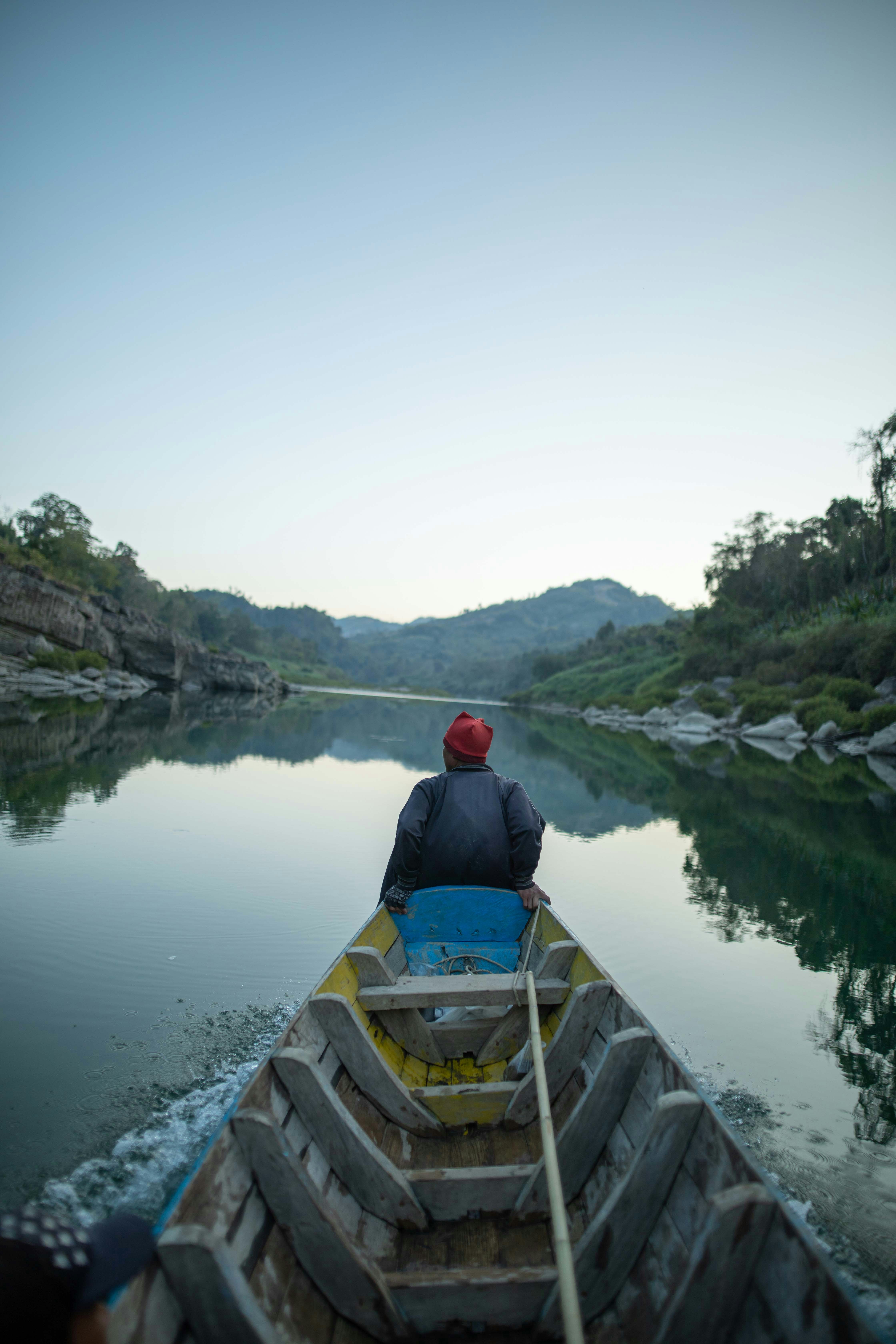 Toward the Quiet Horizon: A Fisherman's Boat Traverses a Dawn-Soft River