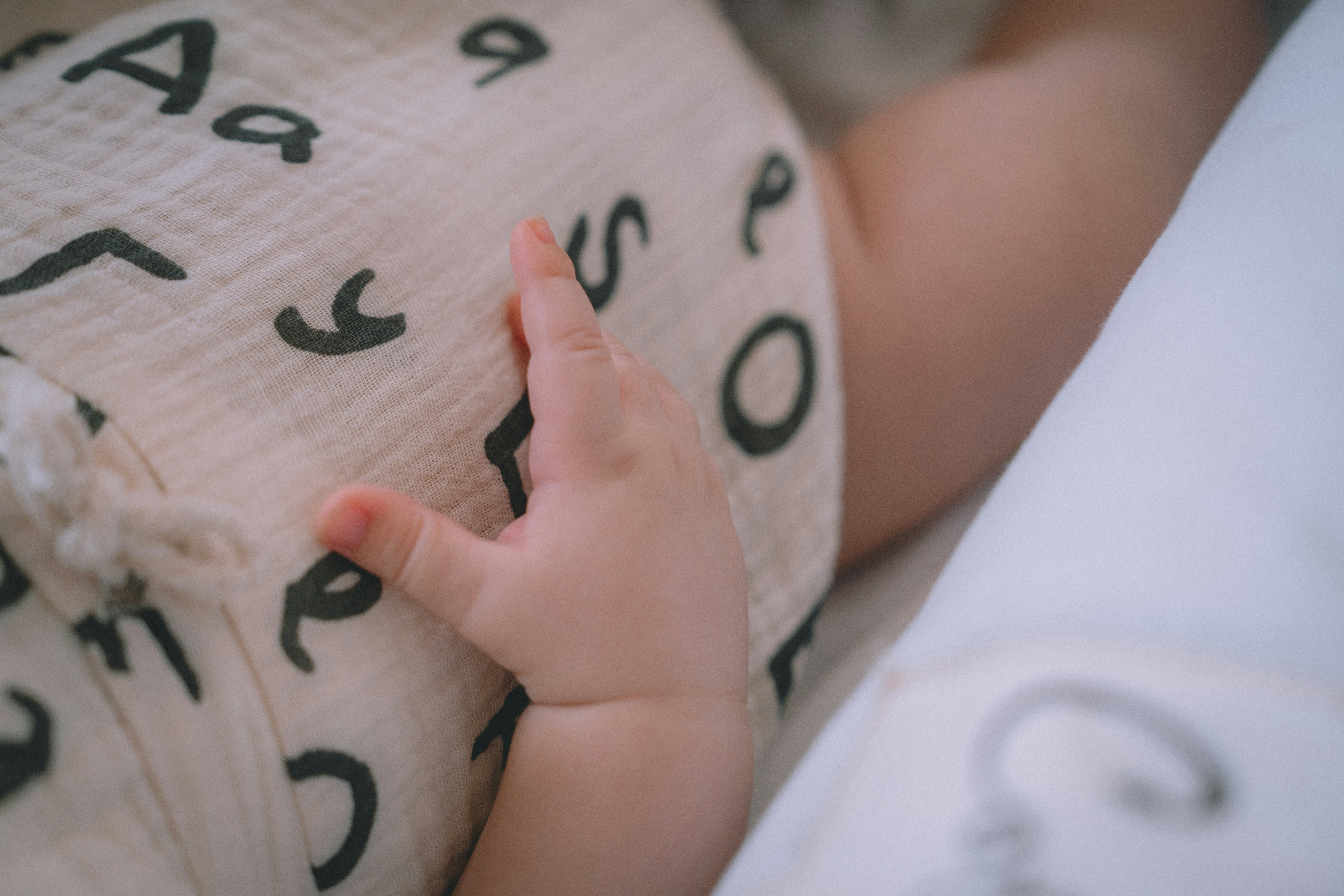 Gentle Touch: A Baby’s Hand Resting on a Patterned Fabric