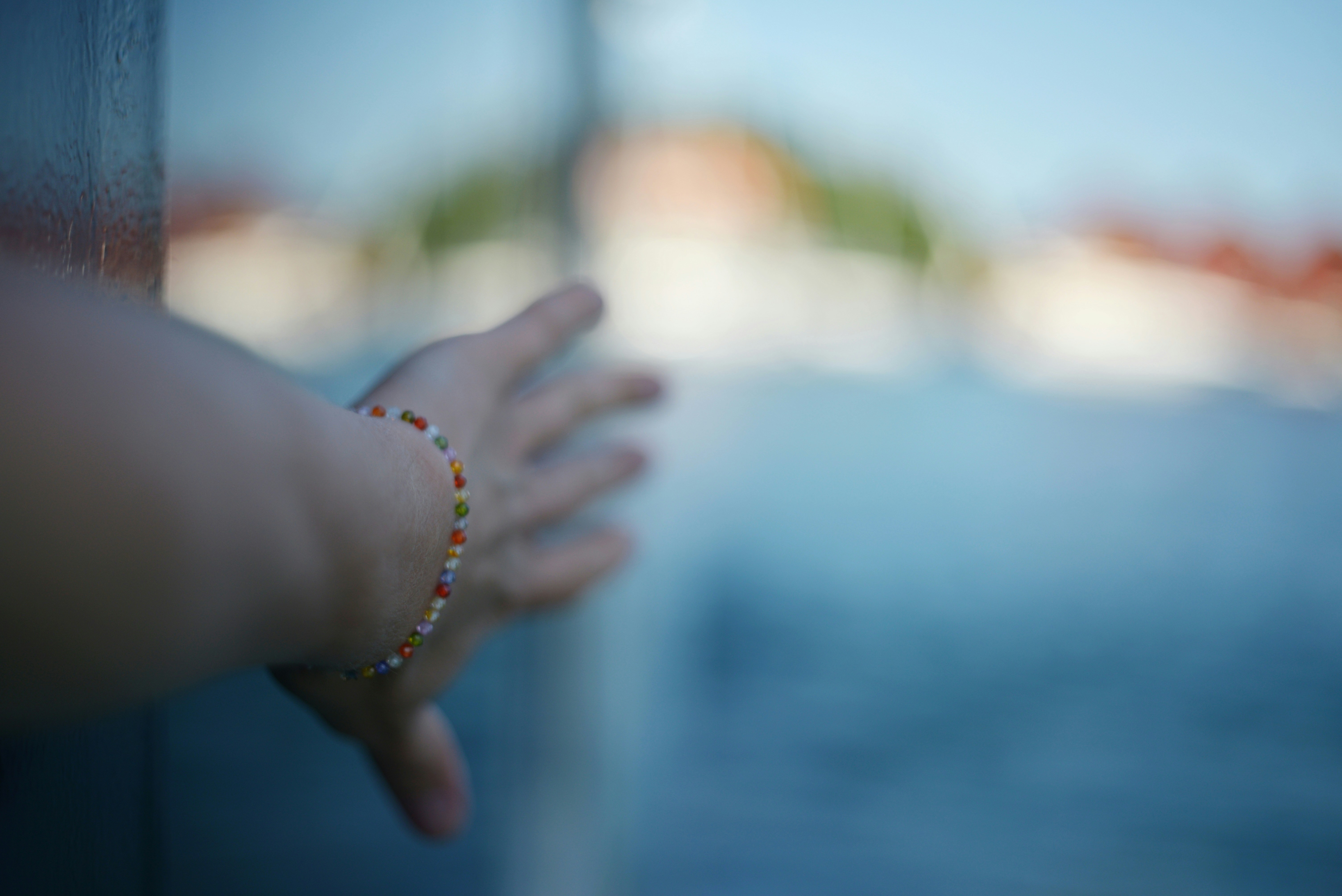 Outstretched Hand by a Glimmering Waterline