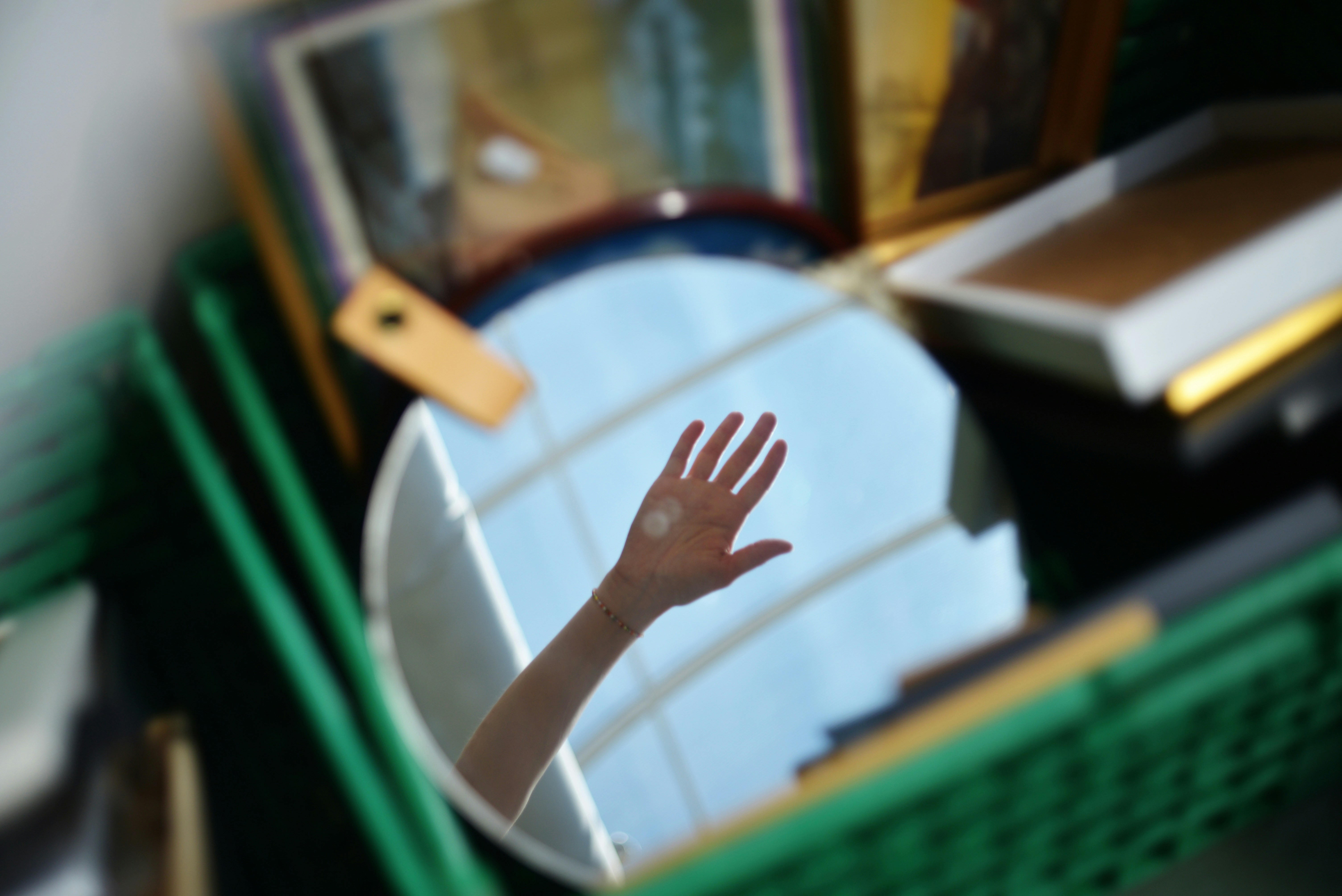 Hand Reaching Through a Distorted Window in a Storage Nook