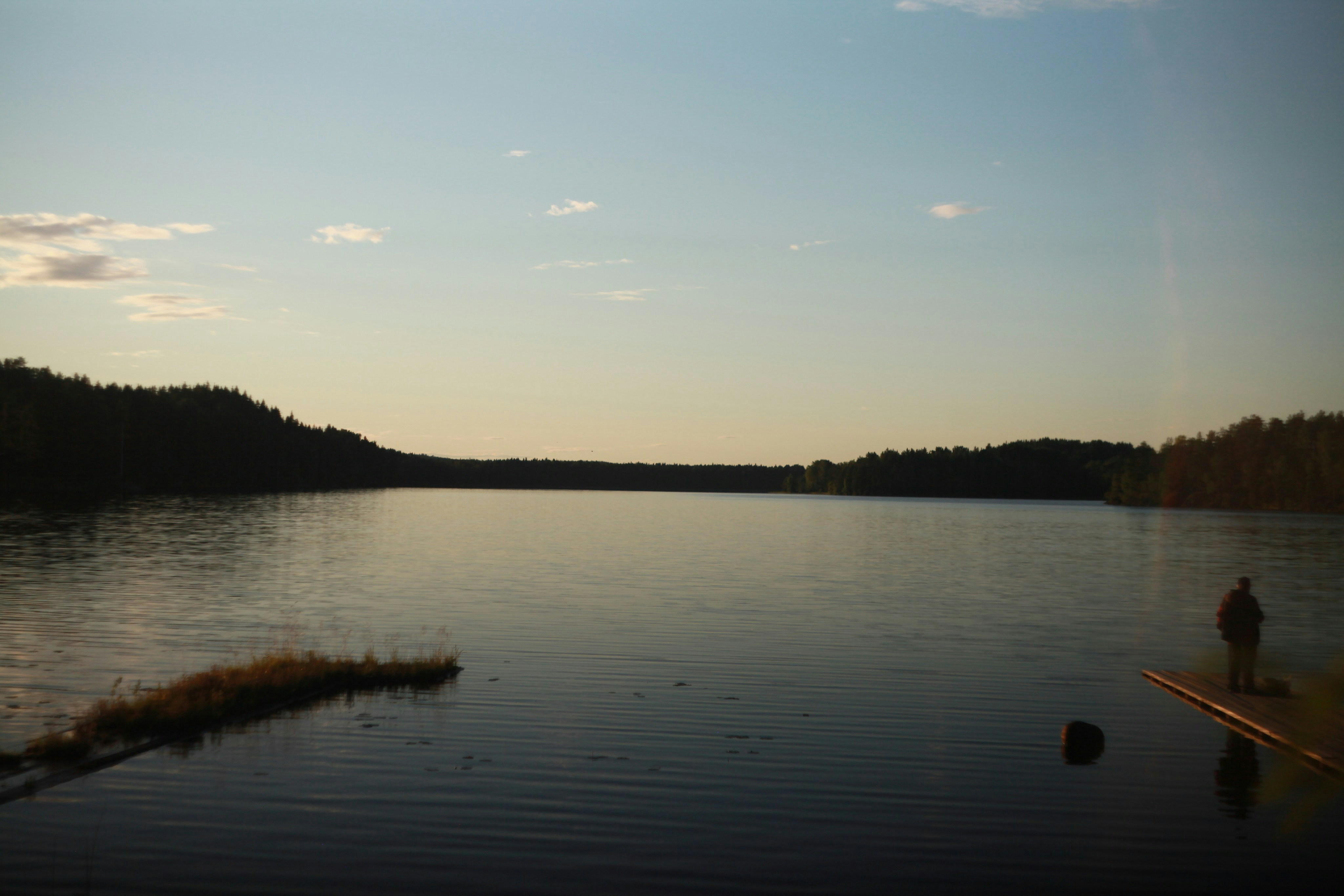 Quiet Dusk Over a Lake: A Lone Paddler at the Water's Edge