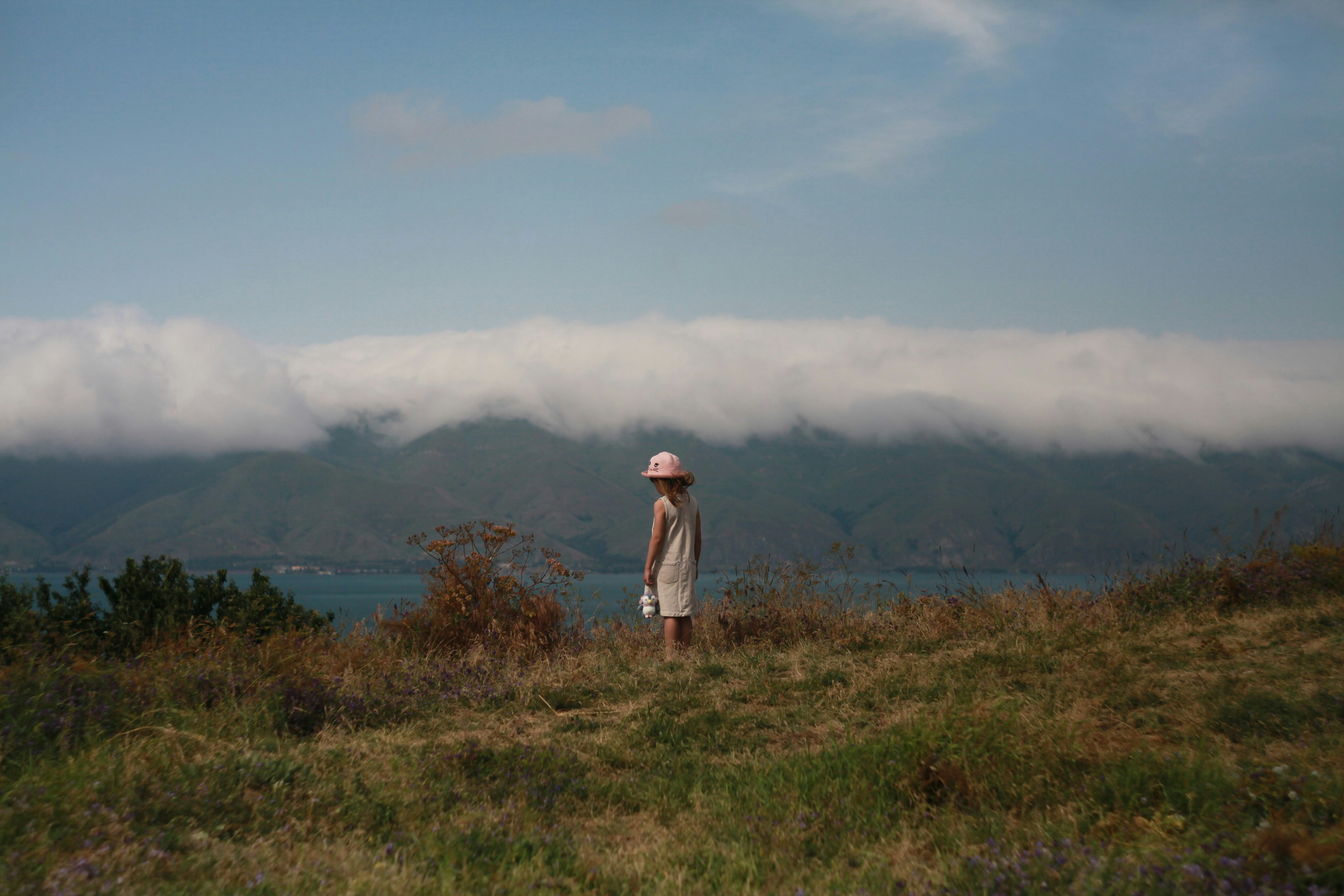  solitary wanderer under a layered sky by the shoreline hills