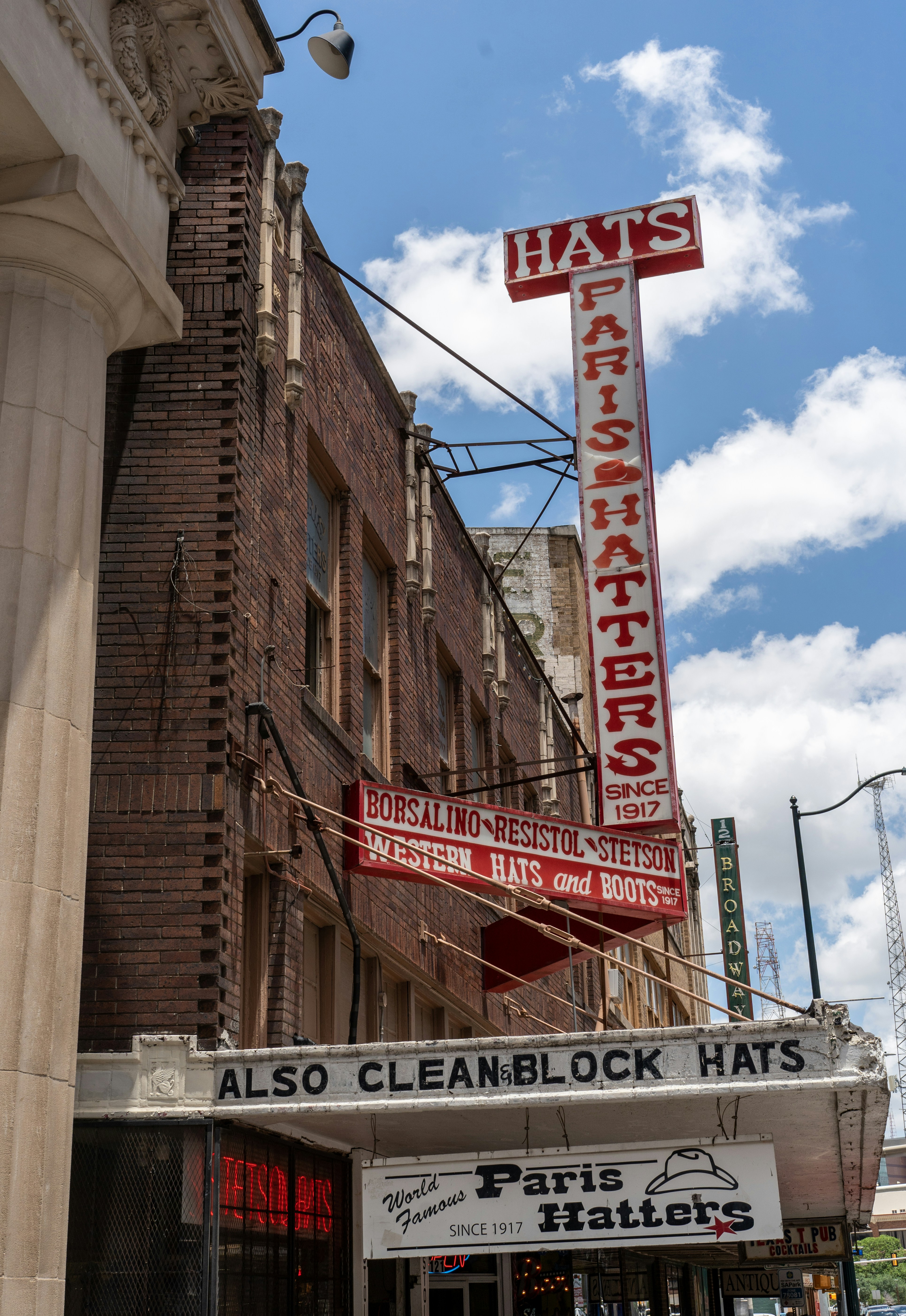Vertical Hats Signposting on a Brick Facade