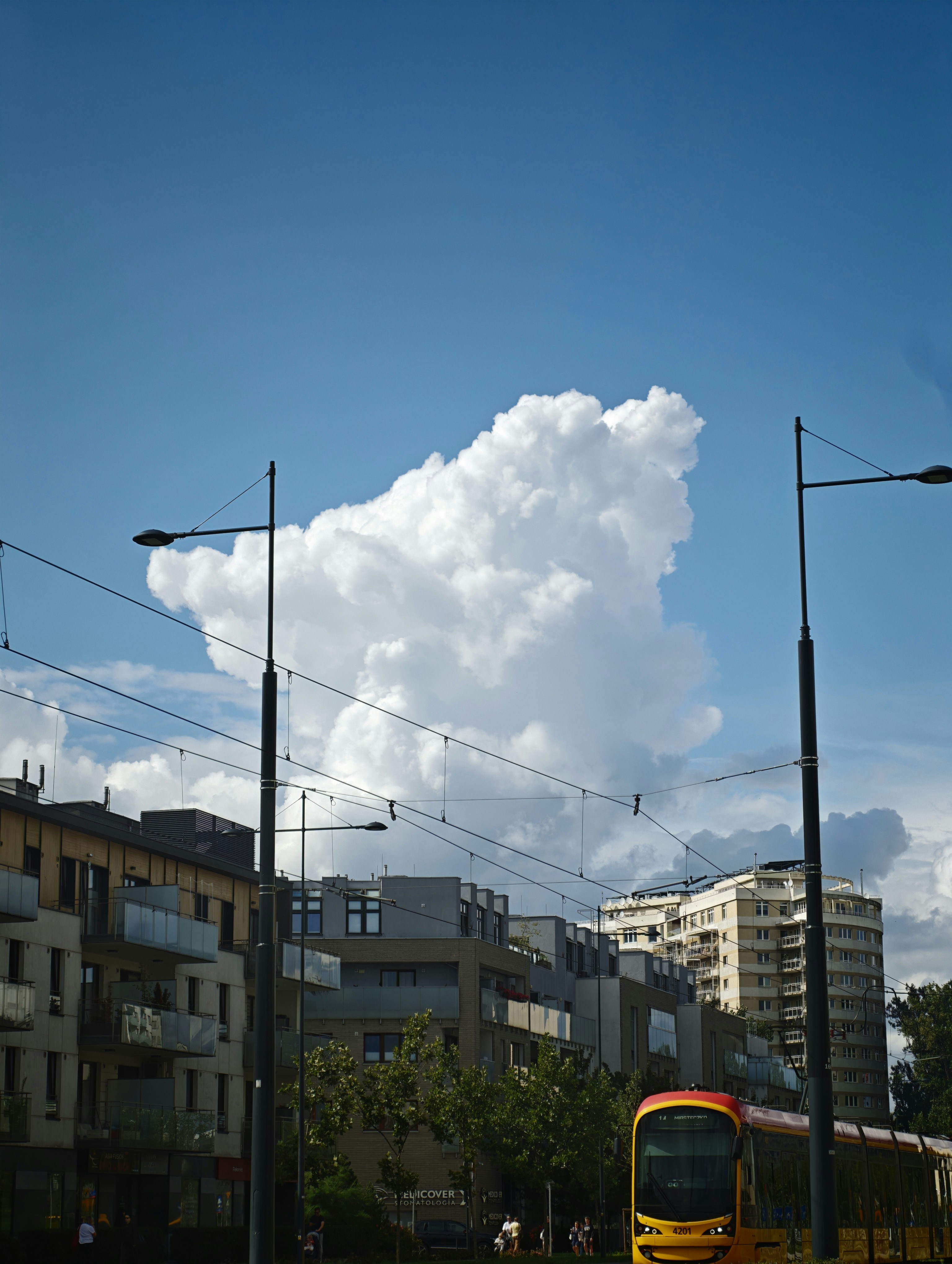 City tram under a towering cloud