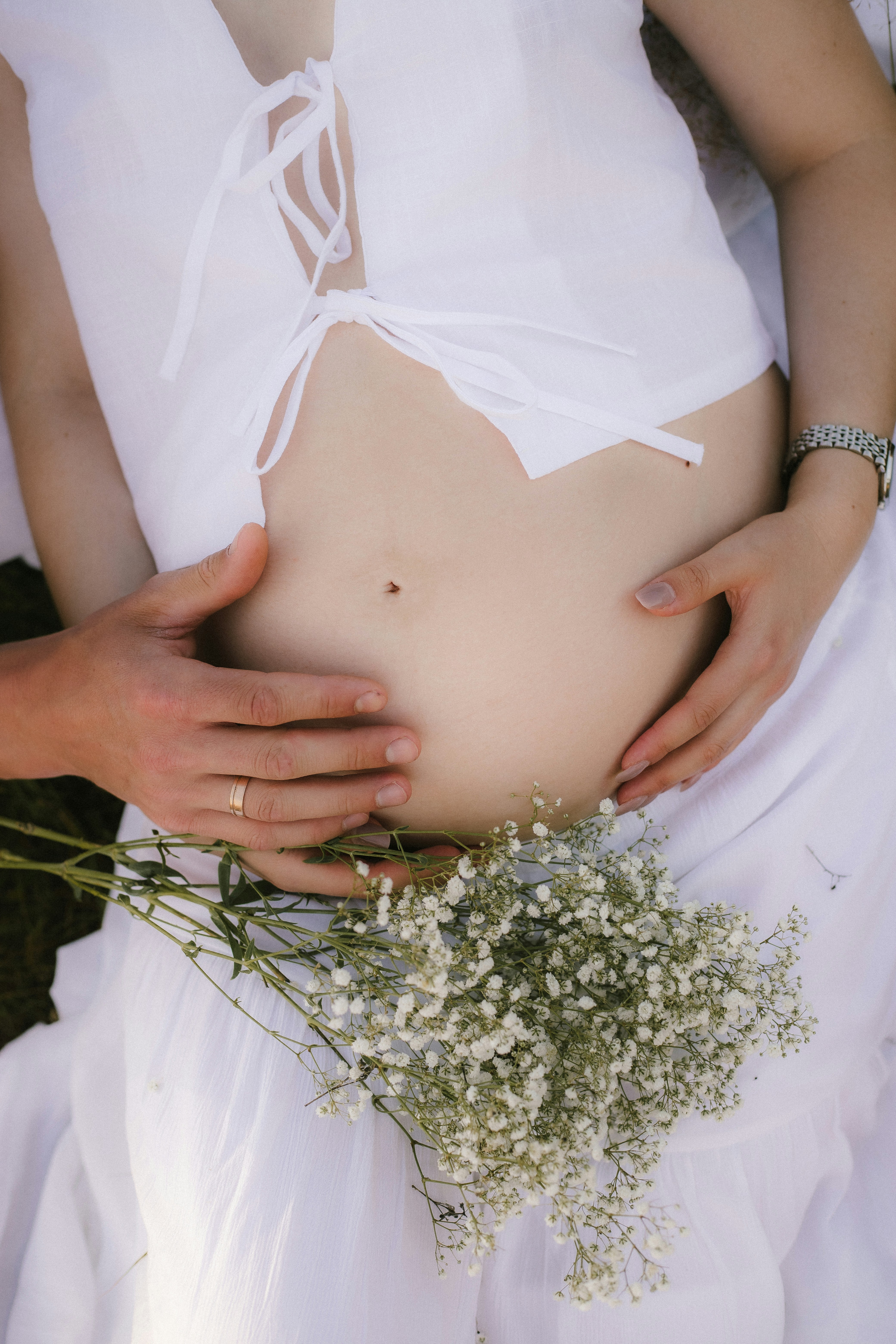 Gentle Expectation: A Crooked Smile Over a Baby Bump Bouquet