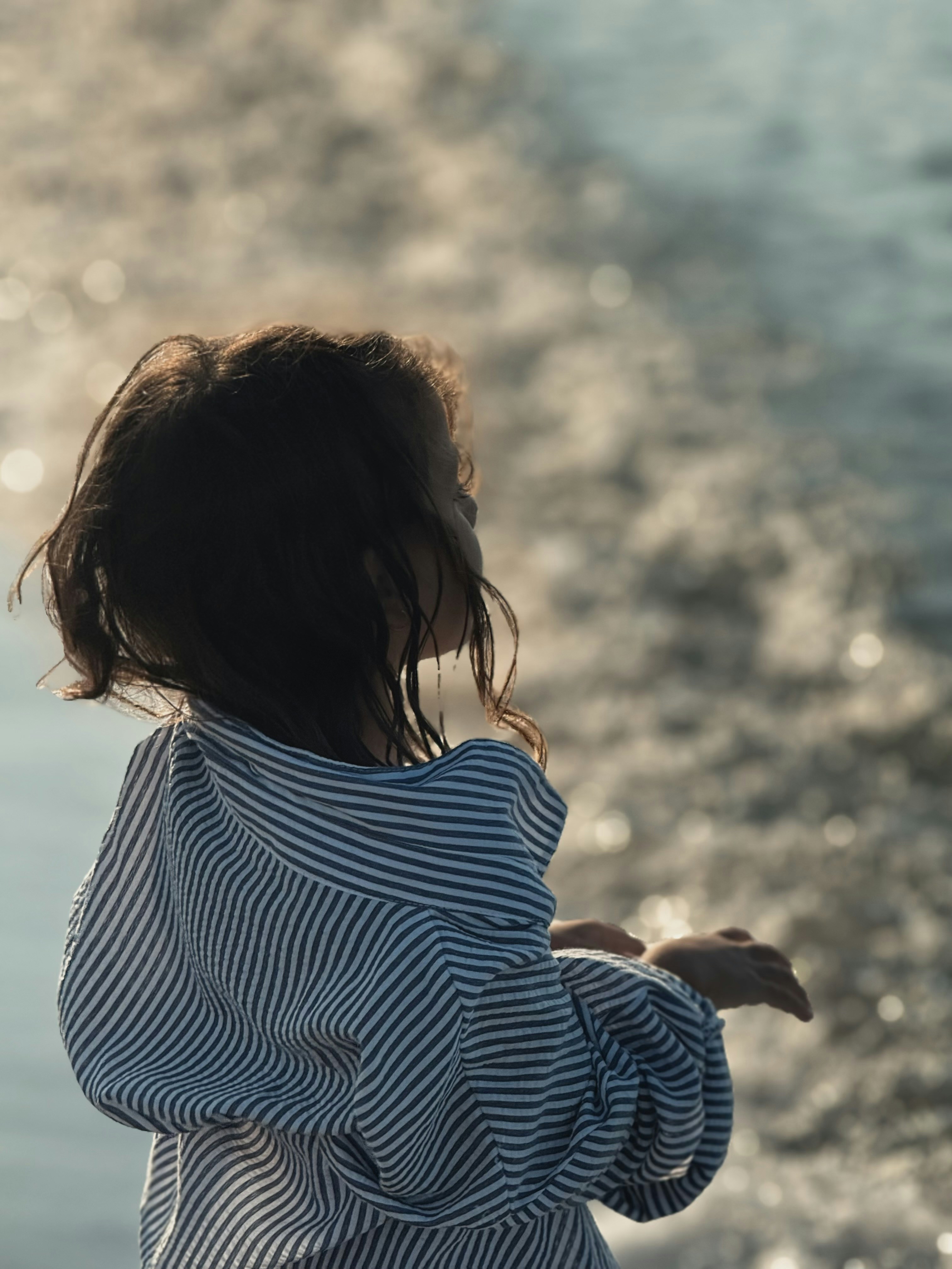 Sunlit Strands: A Silhouetted Moment by the Water