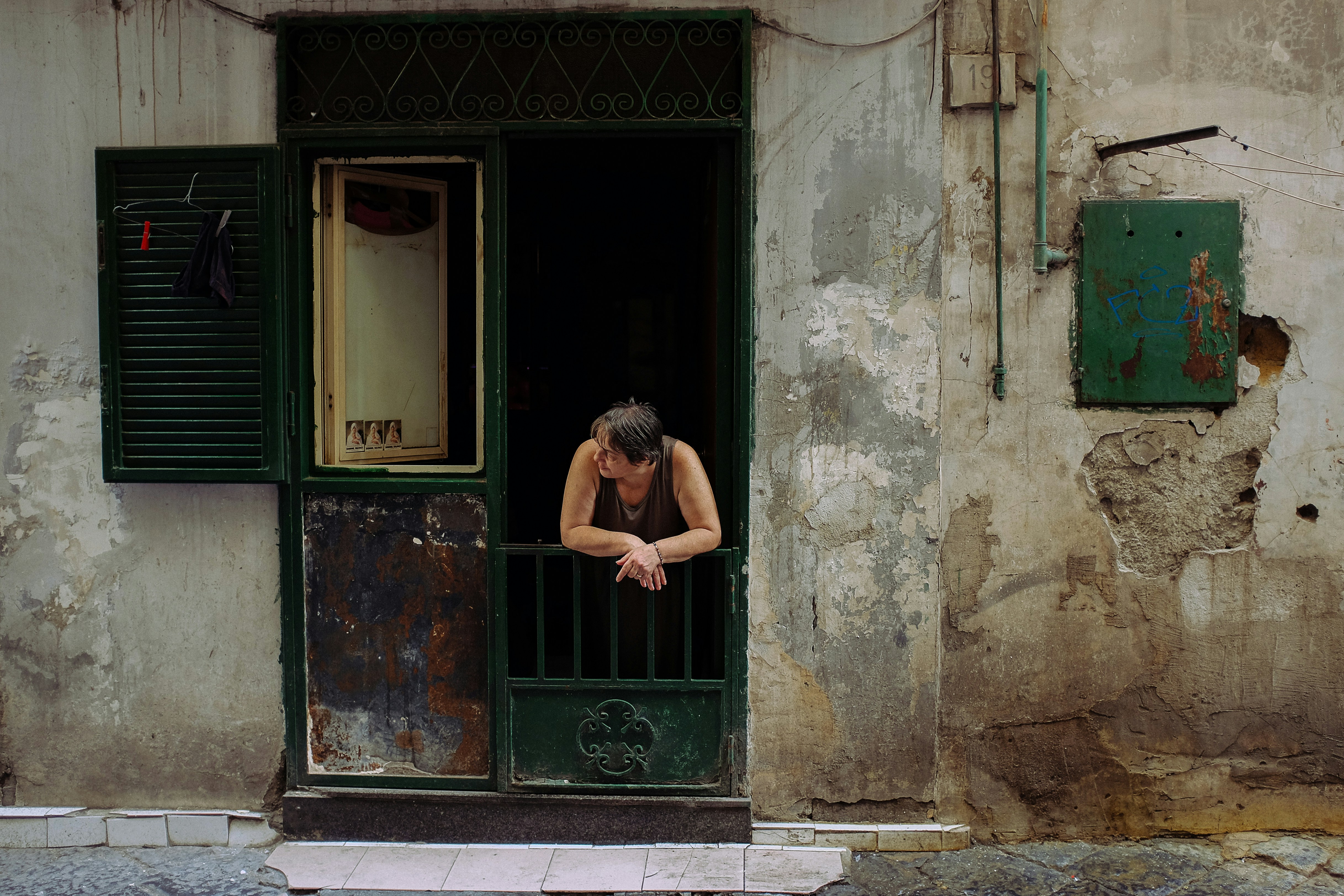 Waiting at the Threshold: A Moment on a Worn Balcony