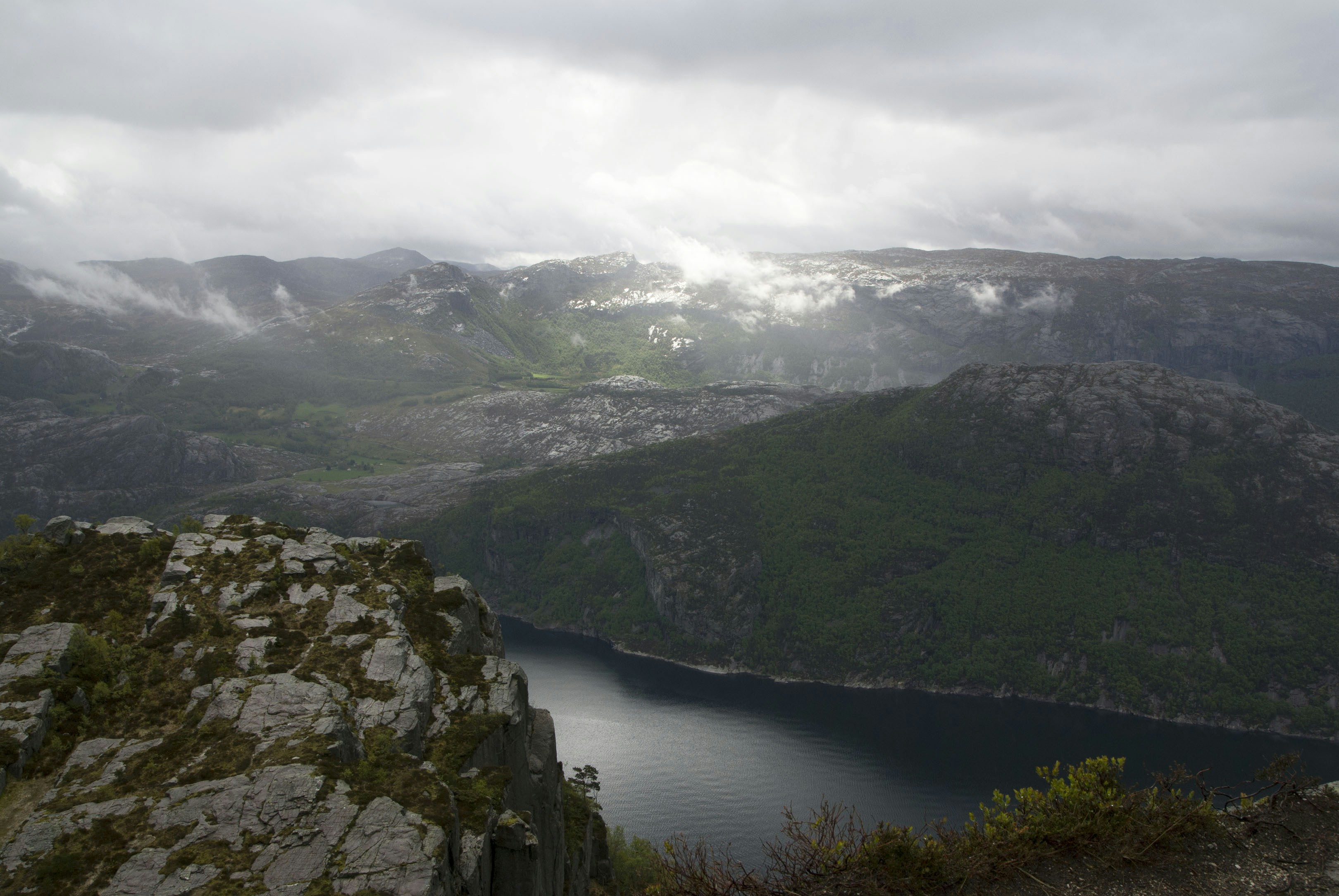 Edge of the Fjord: Cliffside Overlook Beneath Cloud-Capped Peaks