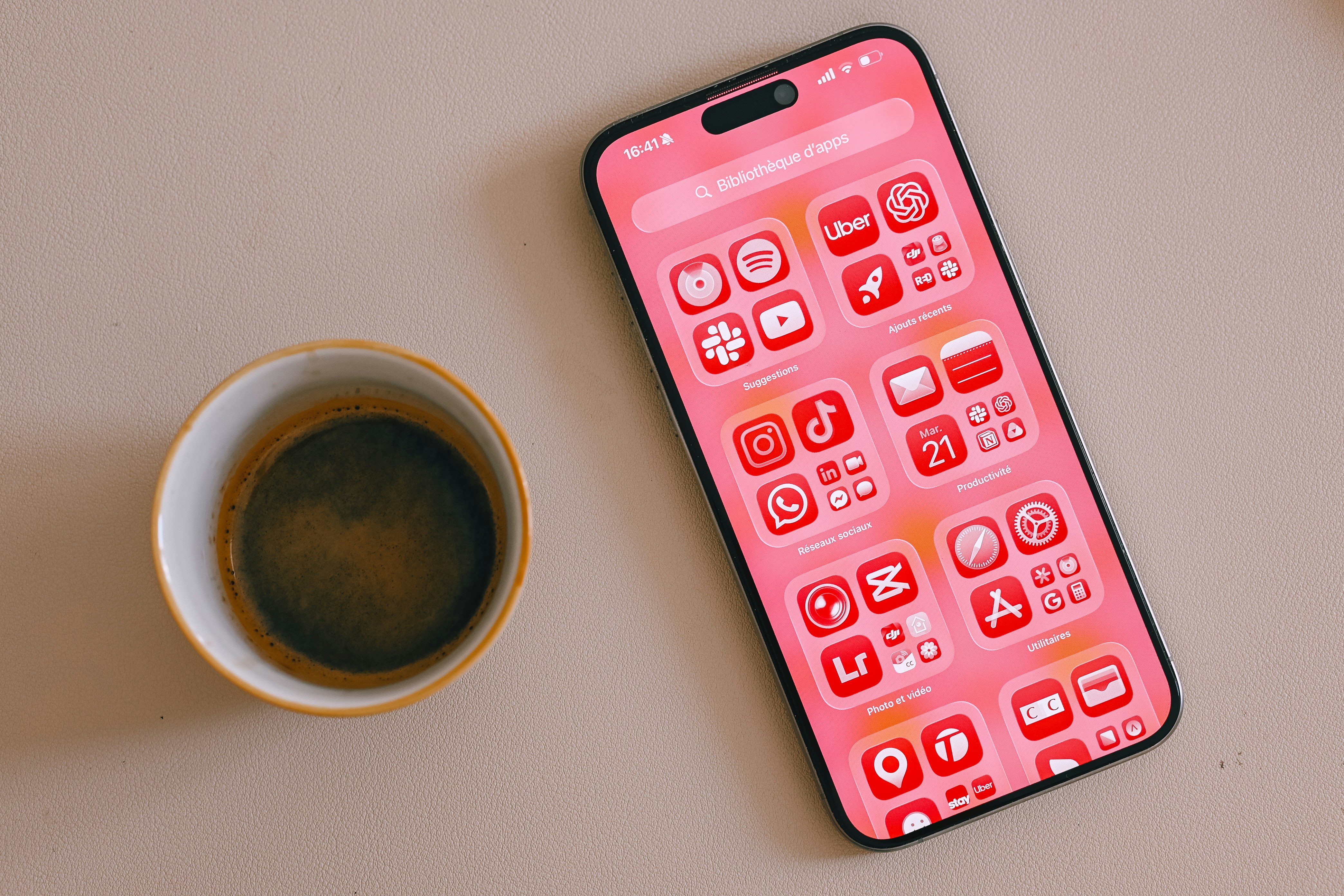 Vibrant Brew at Hand: A Pink-Tinted Phone Grids the Table