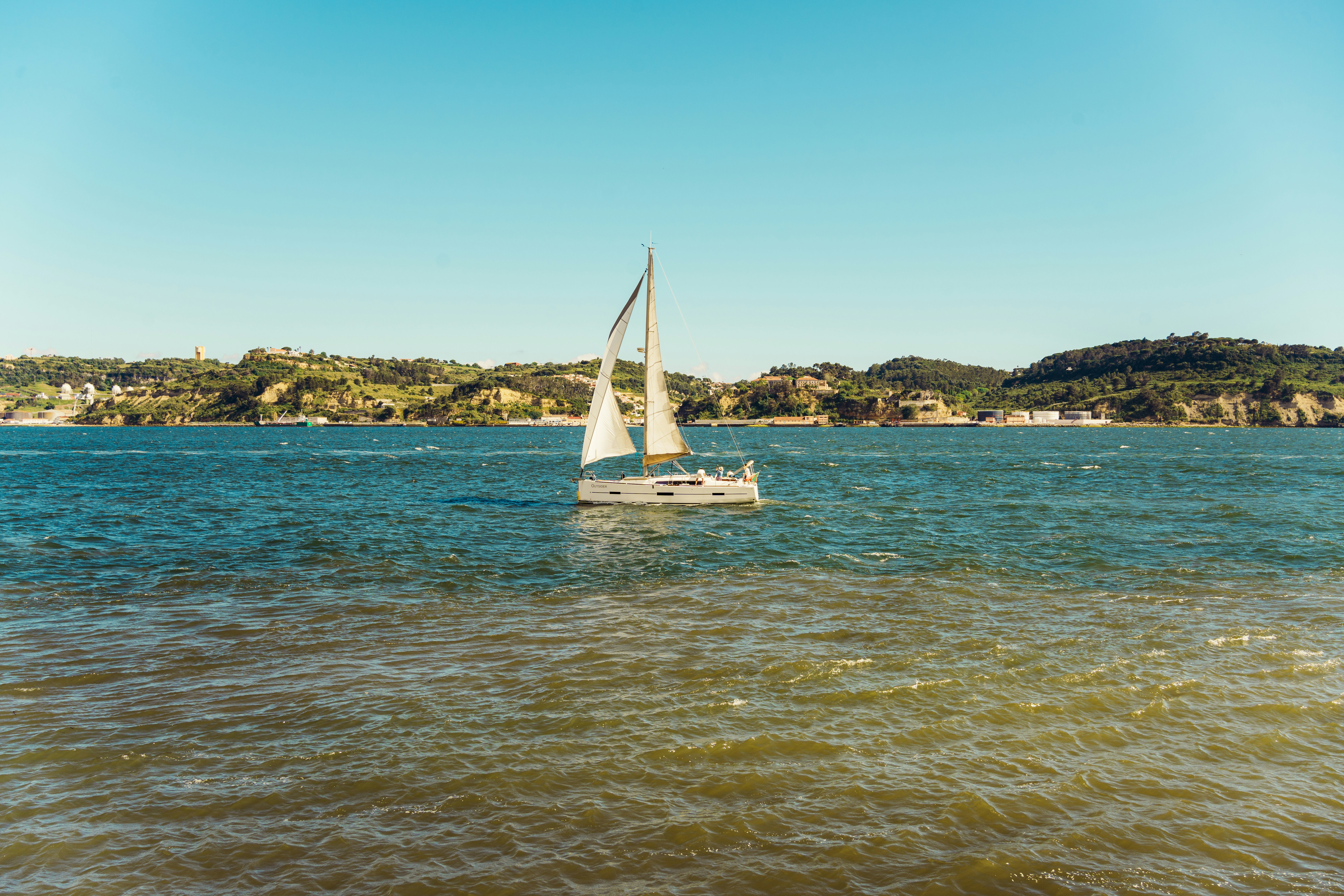 Sailboat Drifts Across a Quiet Coastal Horizon