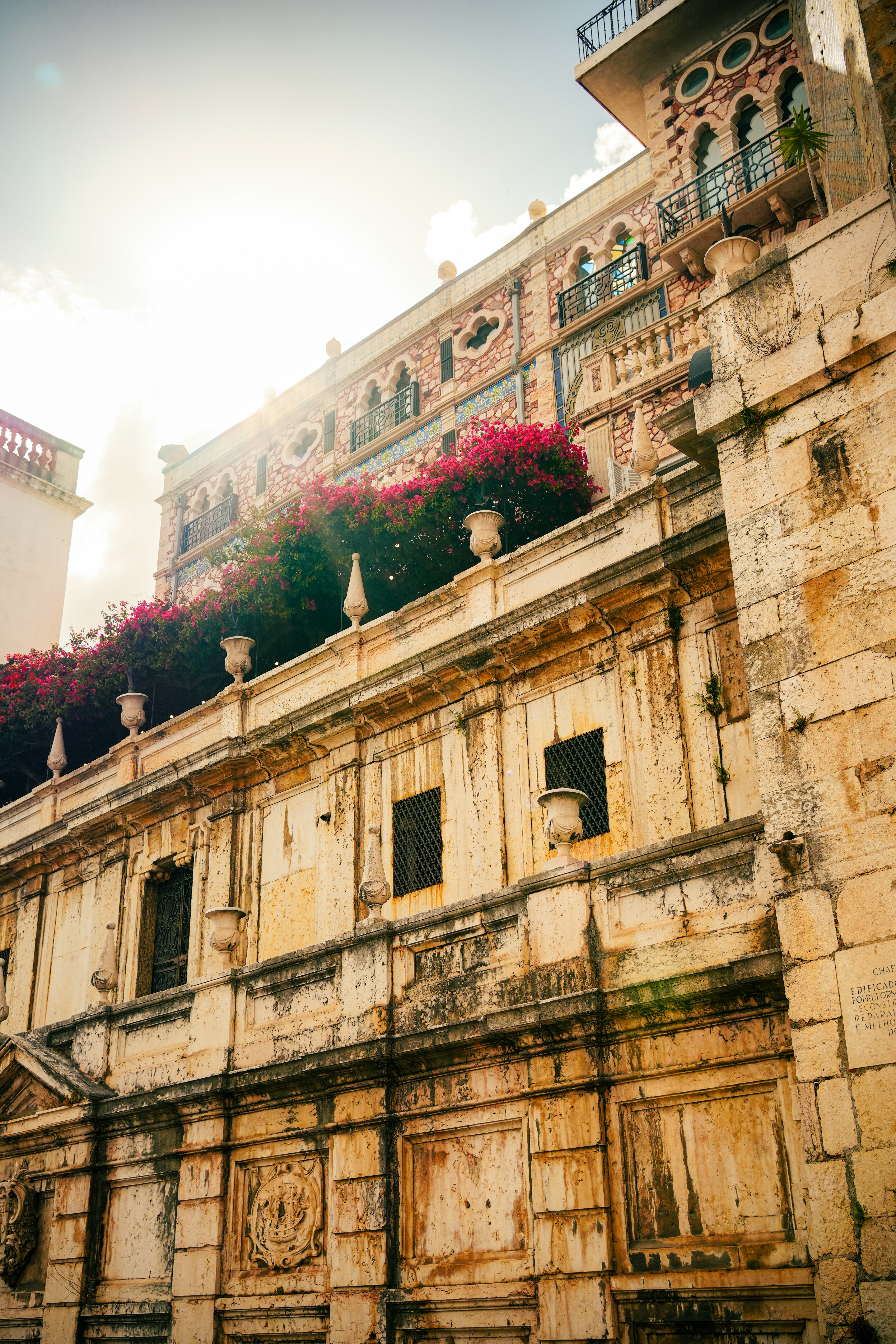 Sunlit Facade Overlook: Florals and Stonework in Warm Italian Light